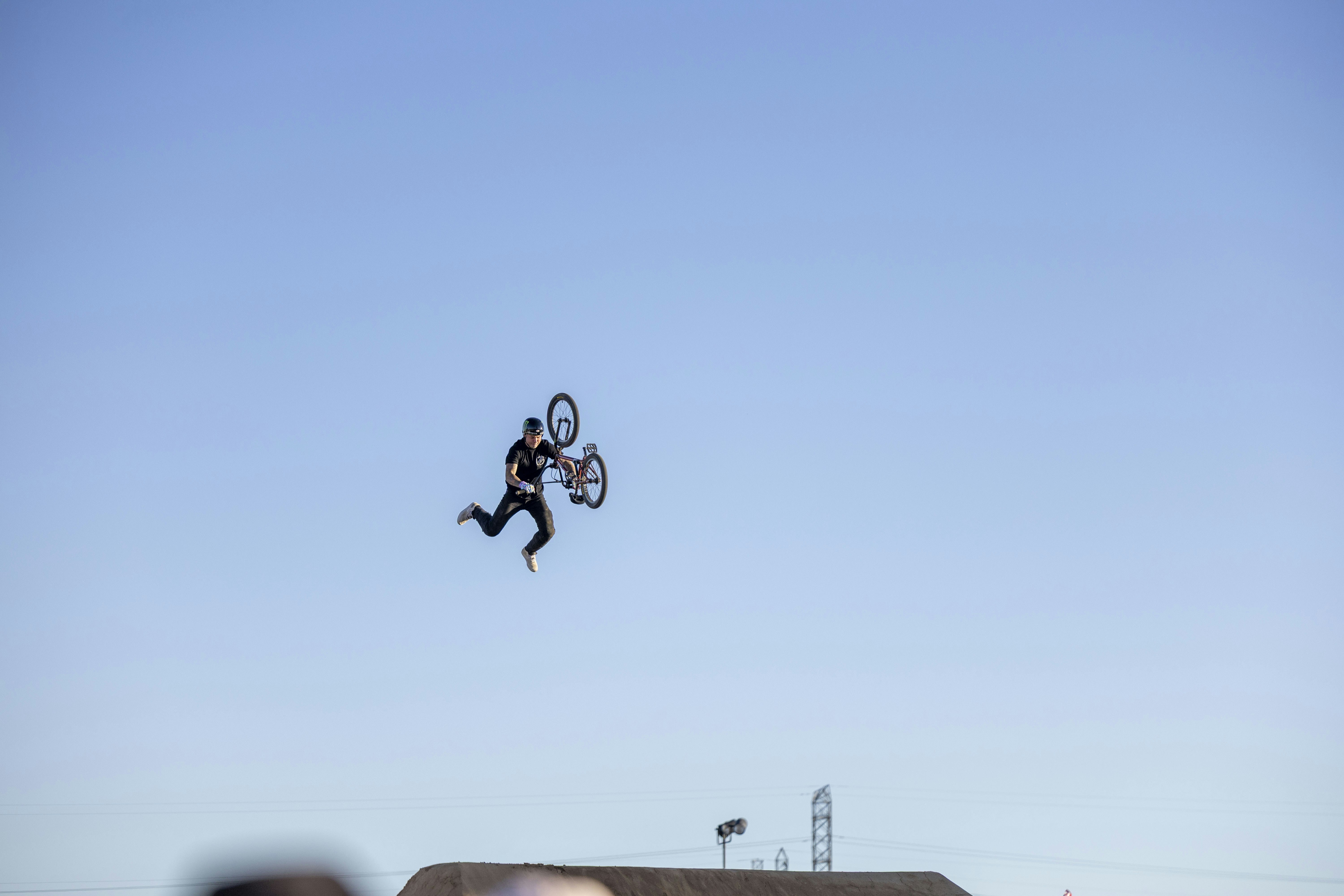 Midair Freestyle: BMX Rider Cleared Over a Distant Rooftop Horizon