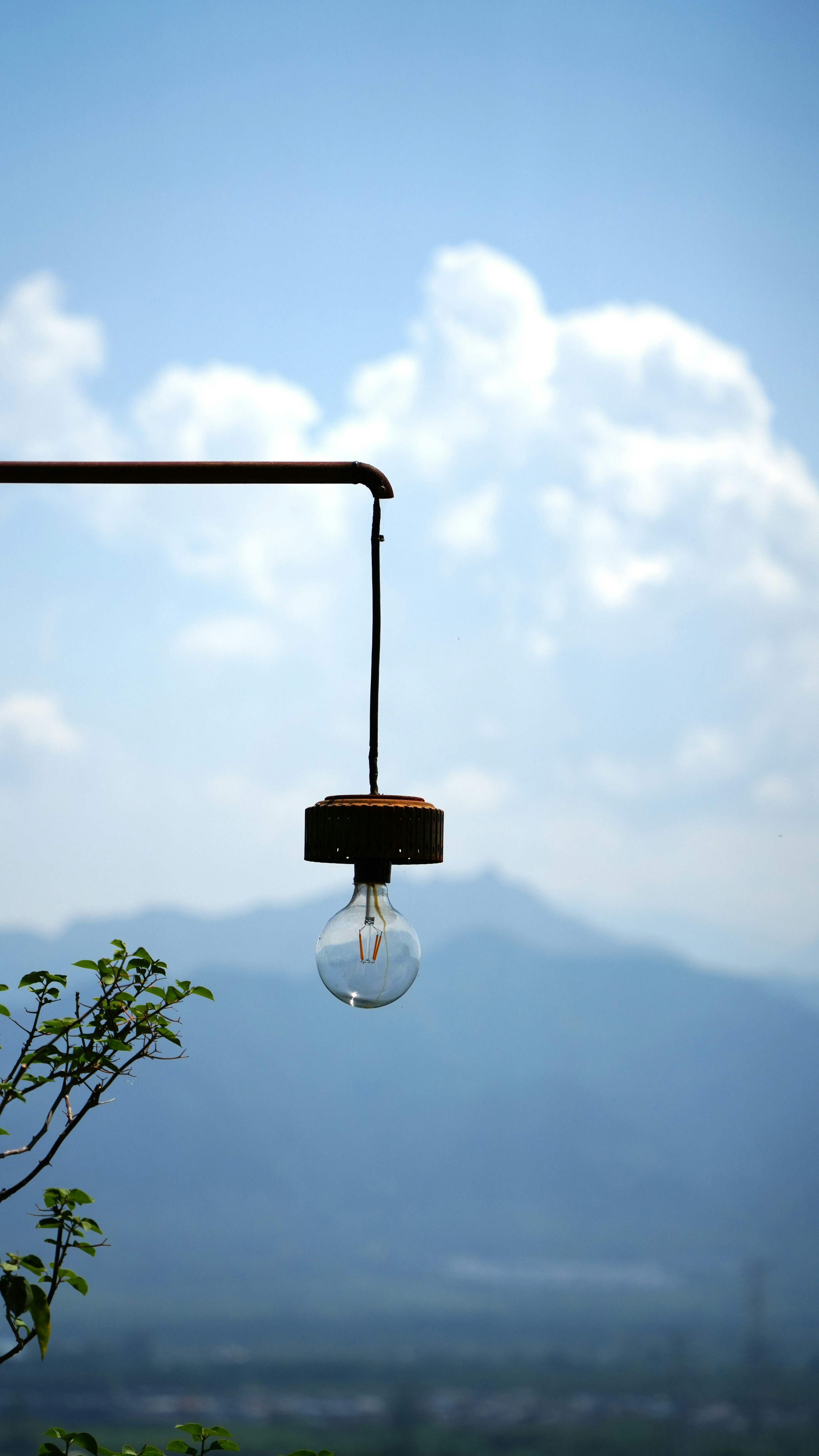 Hanging Bulb Against a Mountain Sky