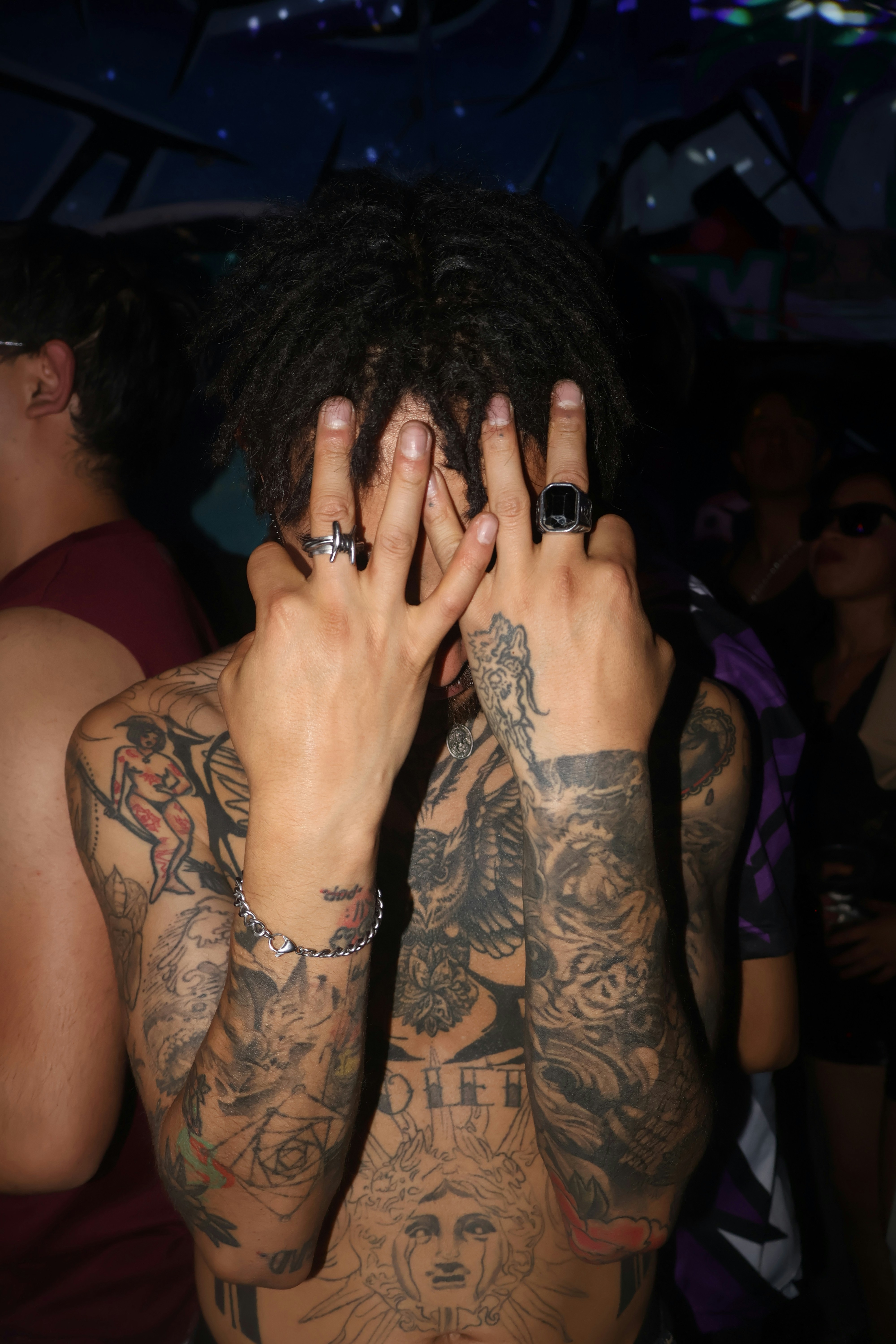 Ink and Shadows: Hands Framing the Tattooed Chest in a Neon Night