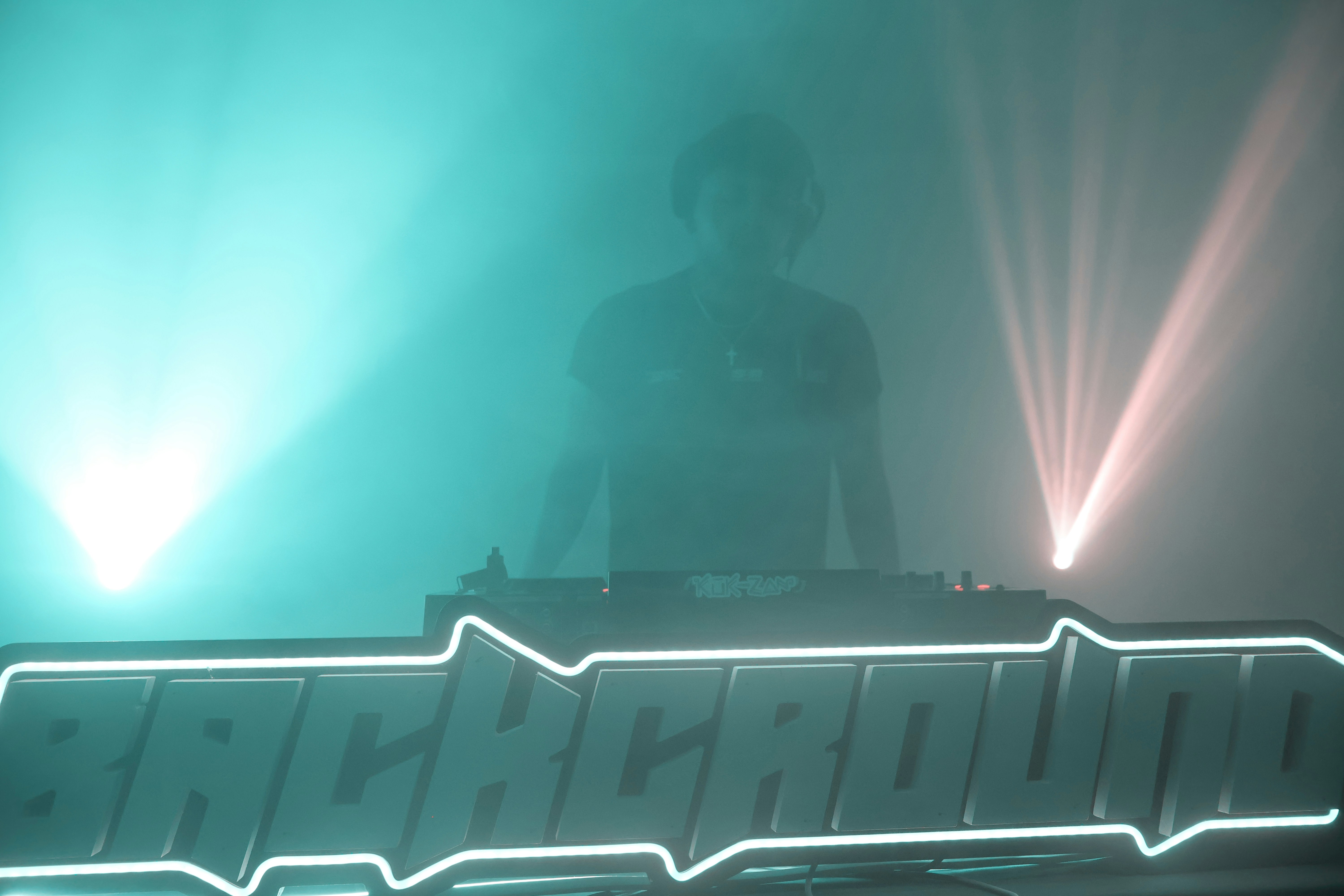 Midnight Pulse: Silhouette of a DJ Behind Neon-edged Booth