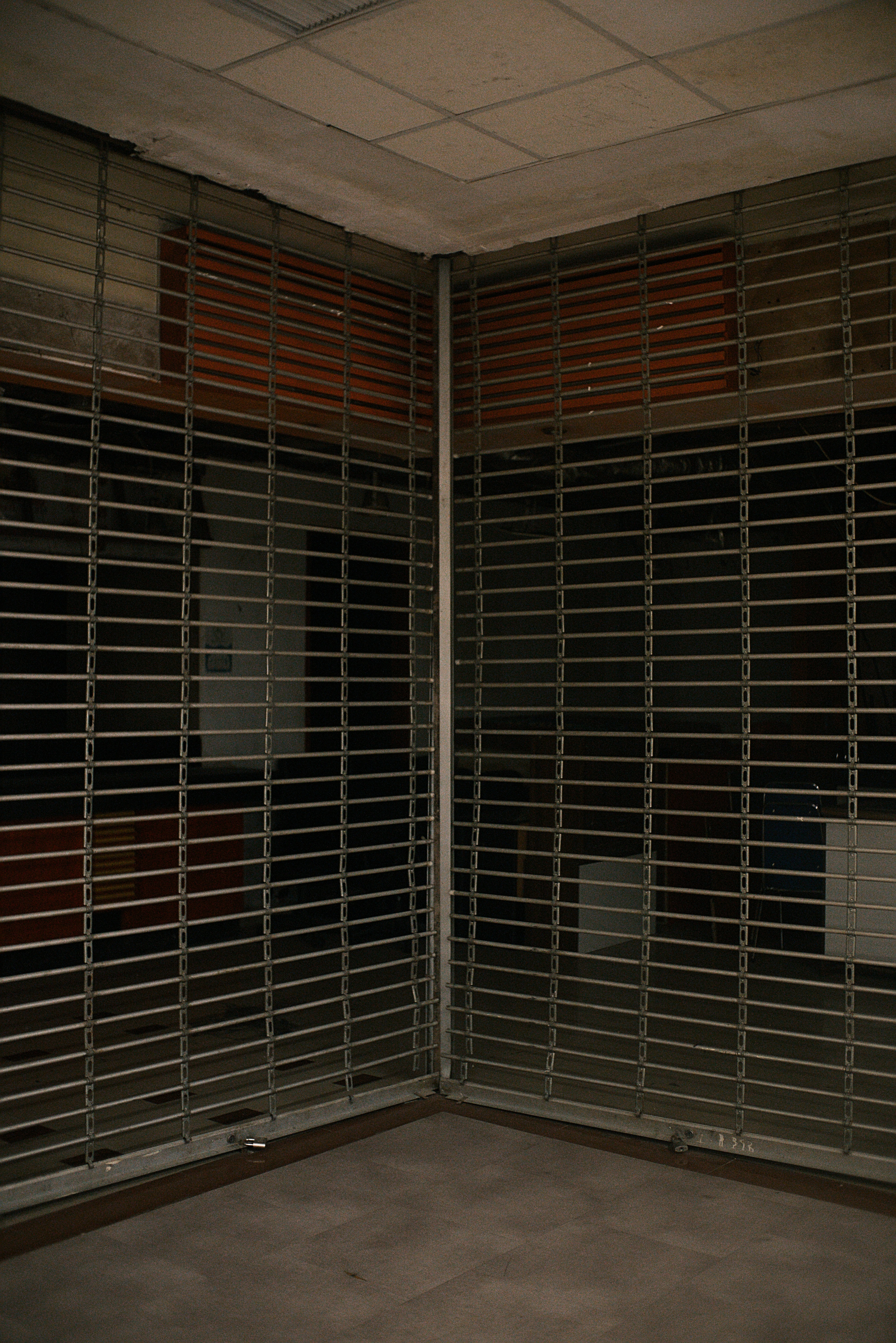 Muted Alleyway Grid: Closed Shutter Corners in Dim Lighting