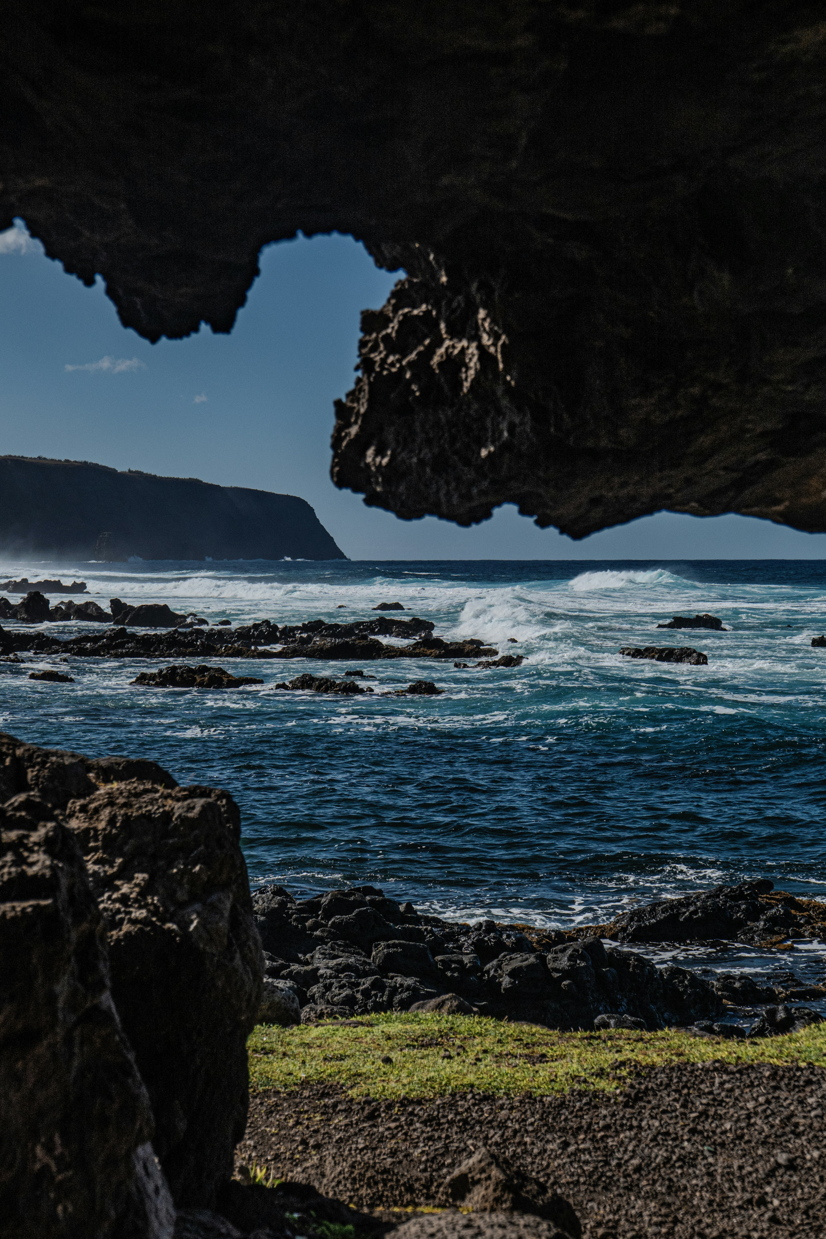 Sea cave framing: cliff edge over turquoise rollers