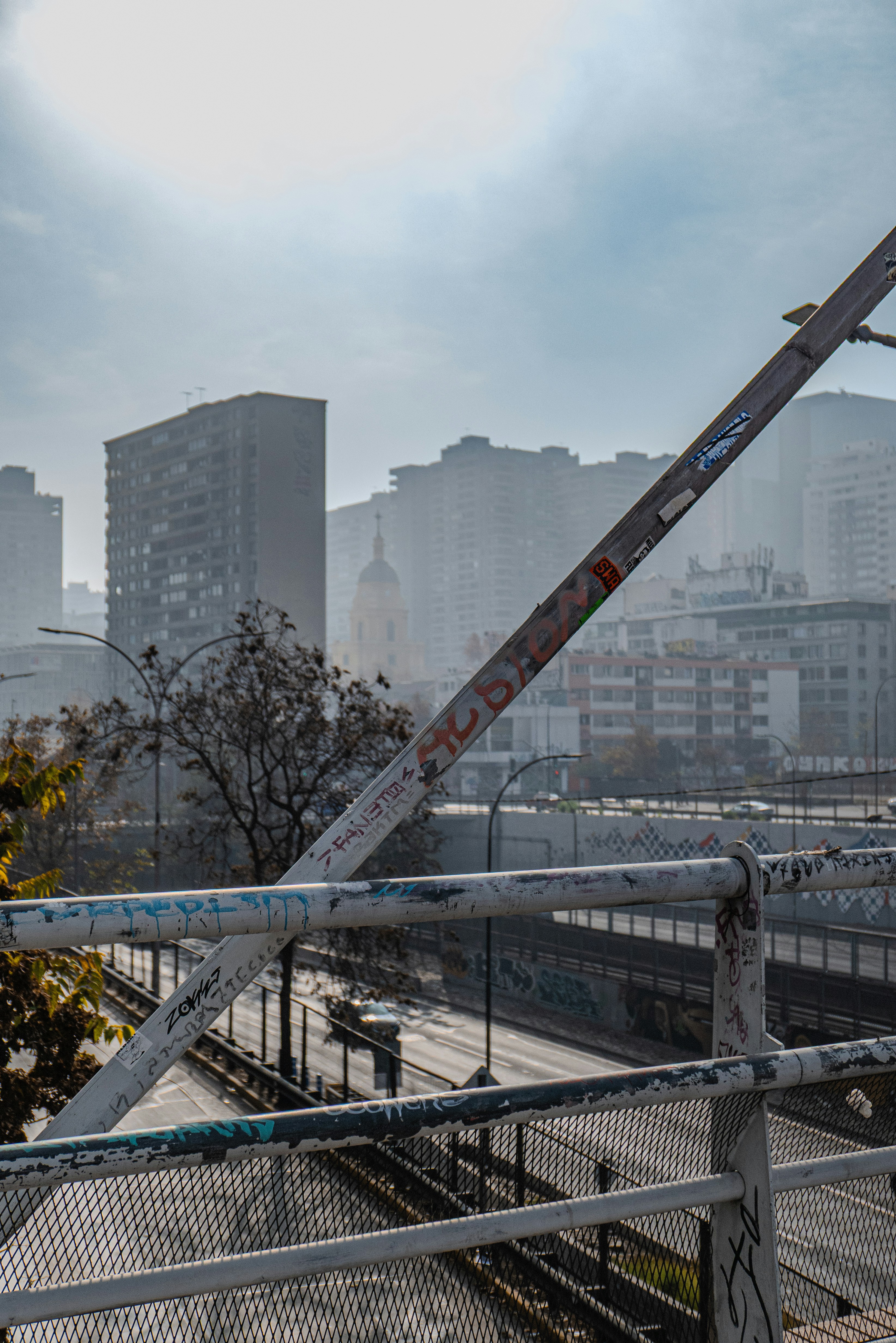 Urban Scaffold: Graffiti Clad Rails Framing a Foggy Cityscape