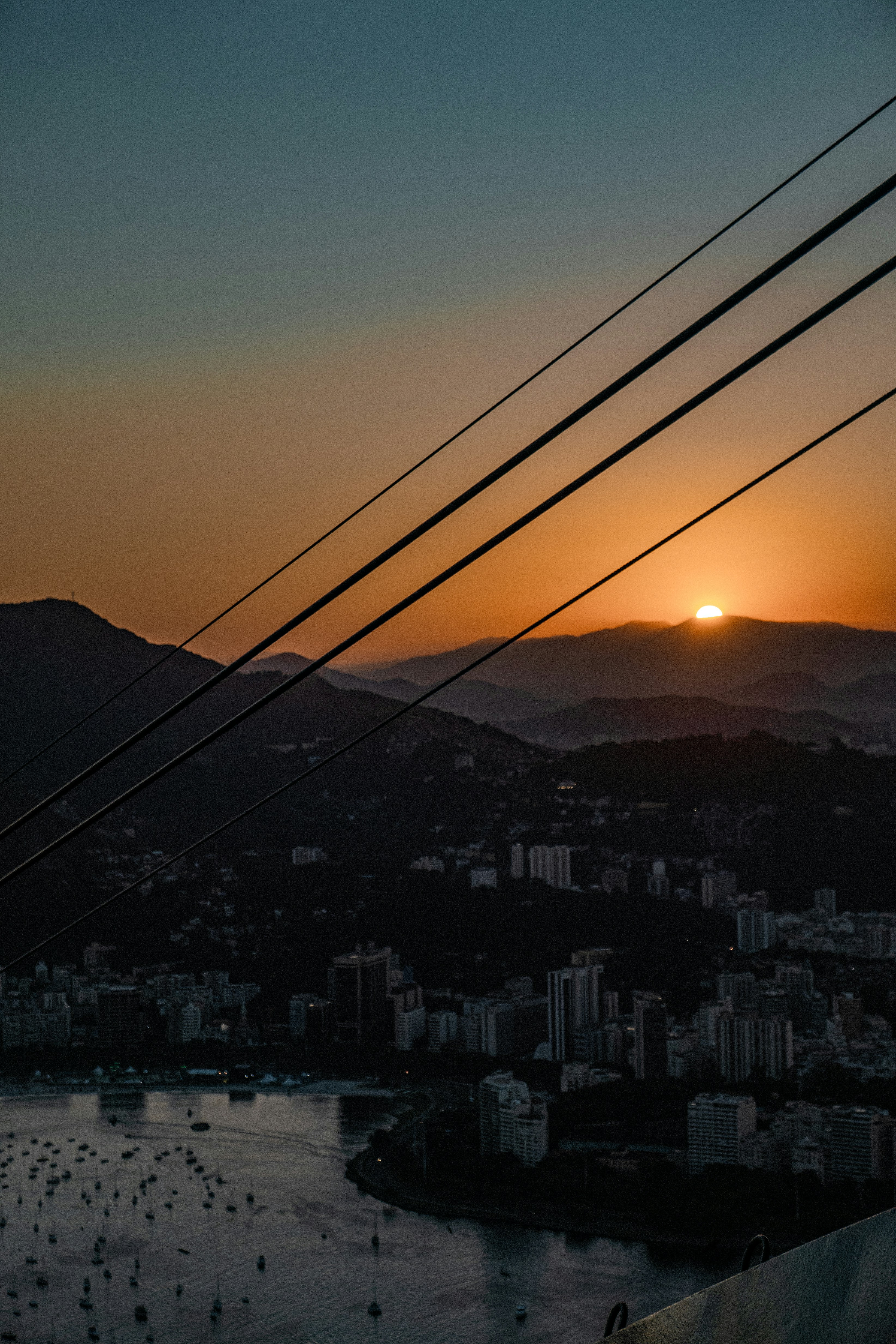 Sunset Over the Coastal City Amid Slanting Cables