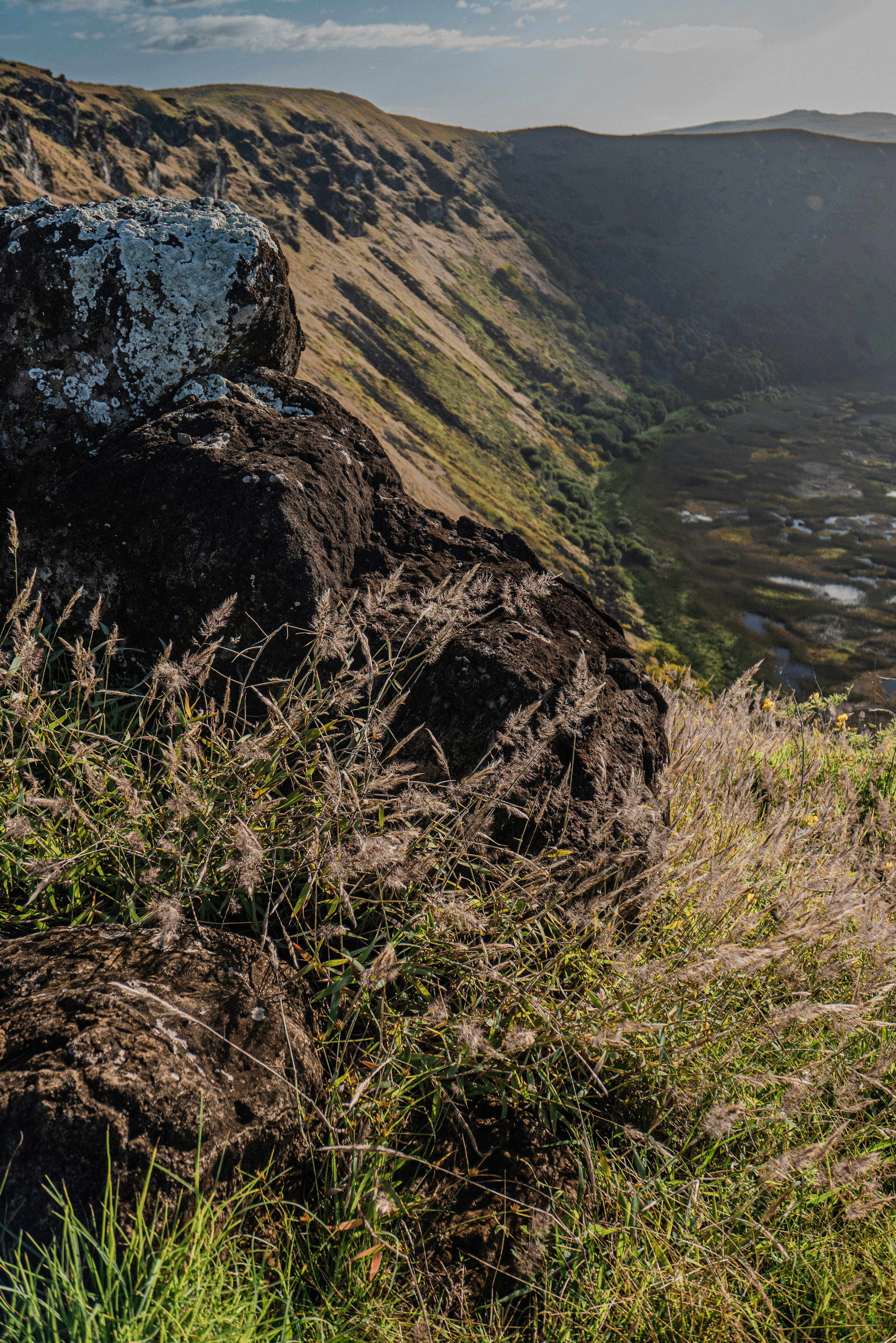 Sunlit Ridge: Weathered Rock and Grasses Framing a Coastal Valley