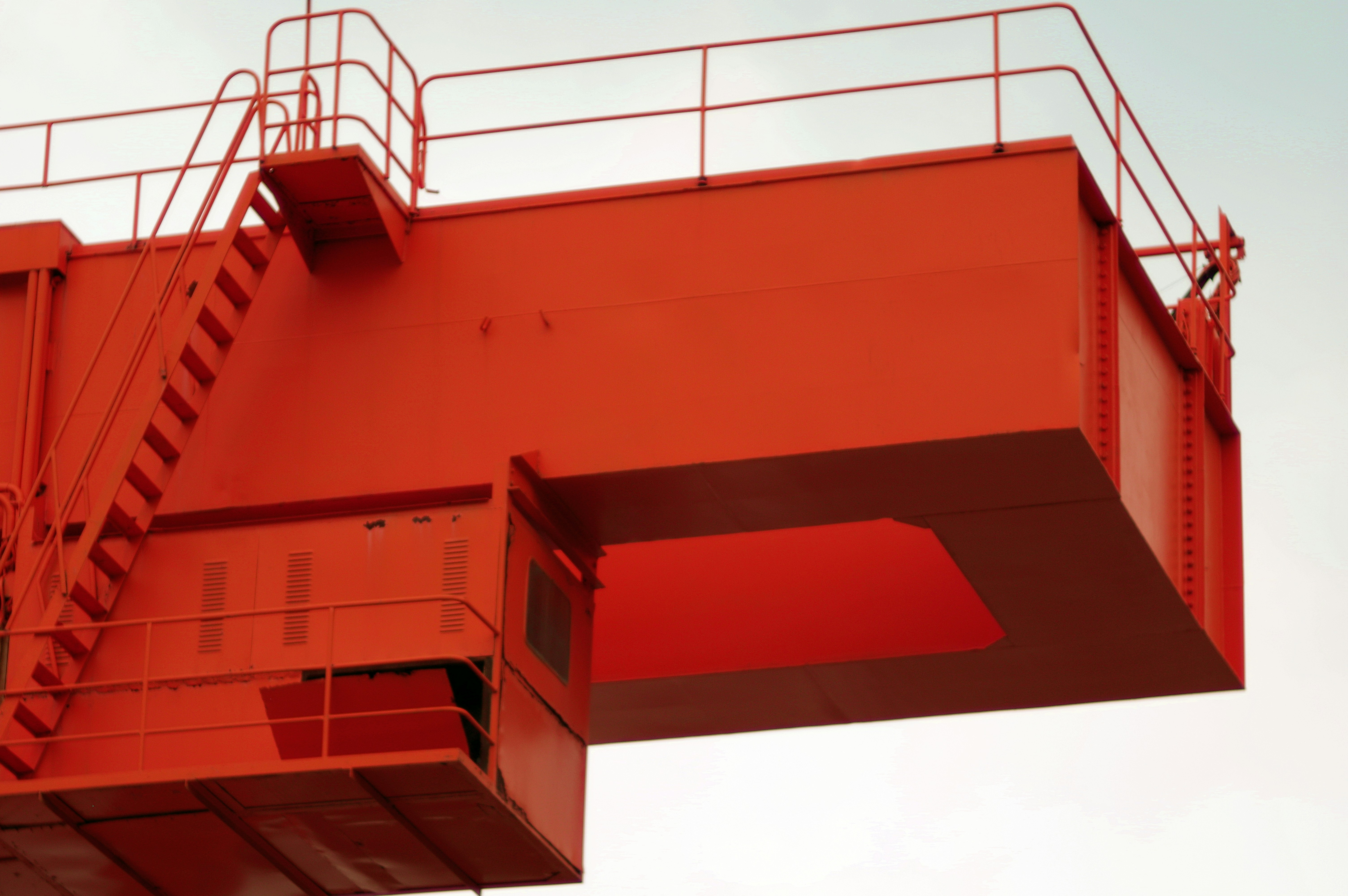 Crimson Crane: A Red Gren Project Docked Against a Pale Sky