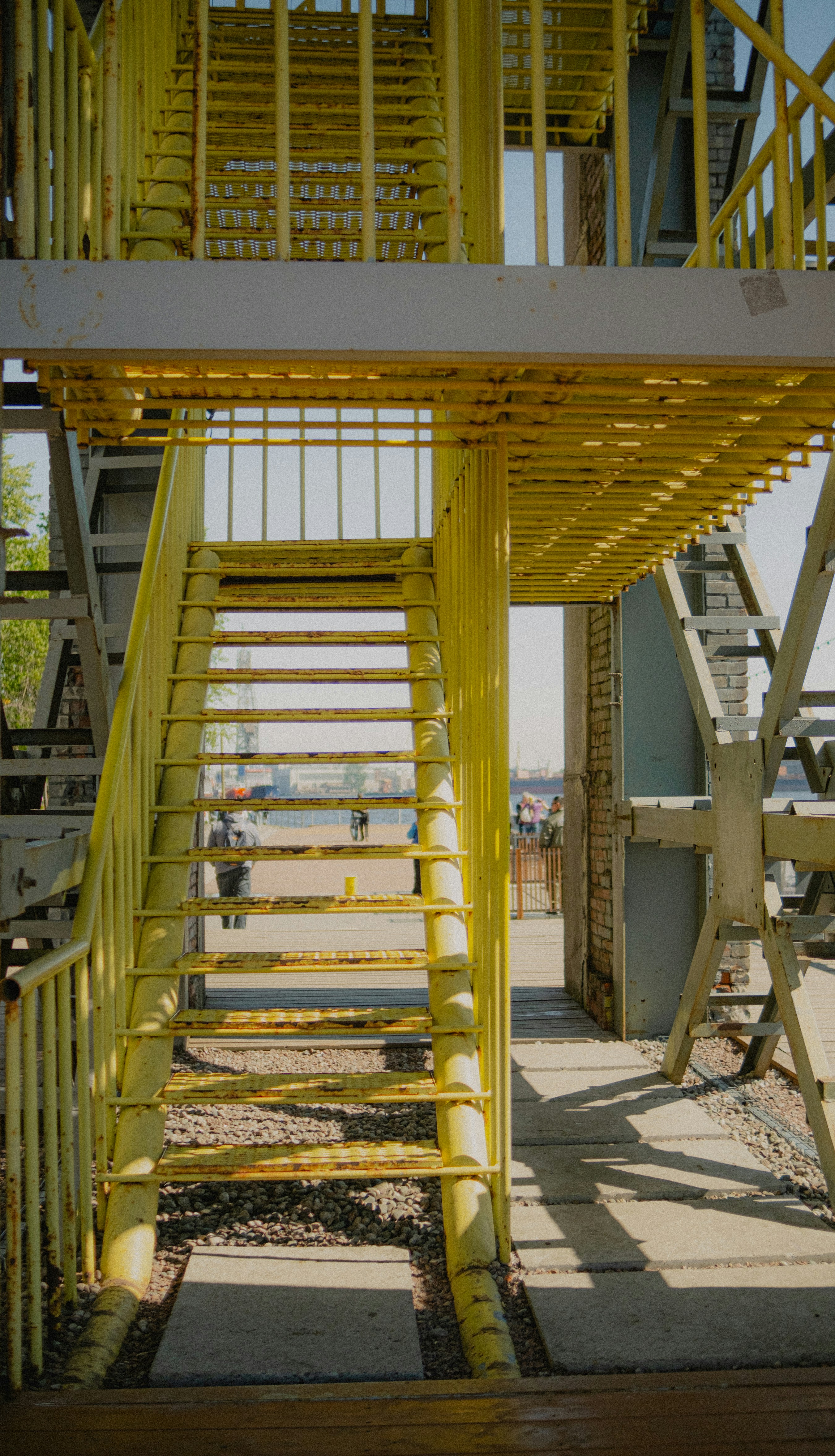 Bright Yellow Staircase Geometry Under Industrial Walkway