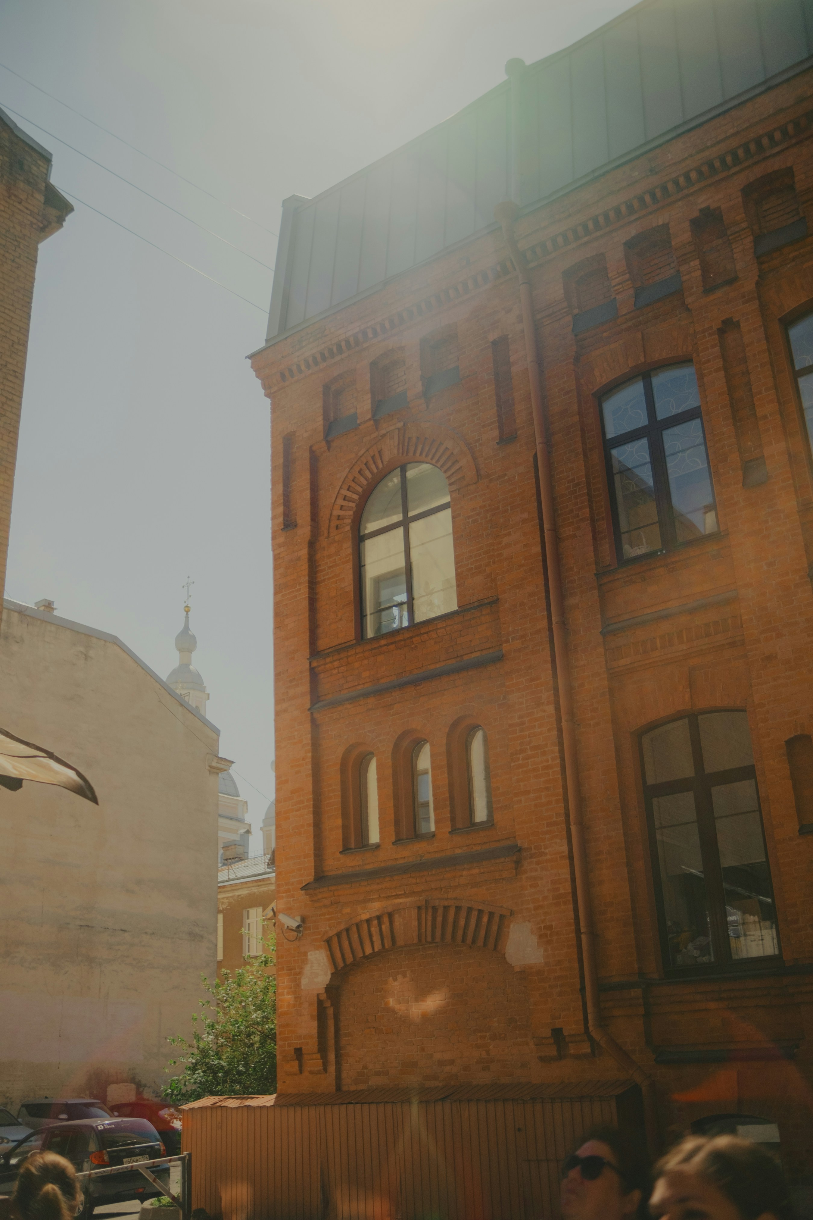 Sunlit brick facade with softened glare and urban silhouettes