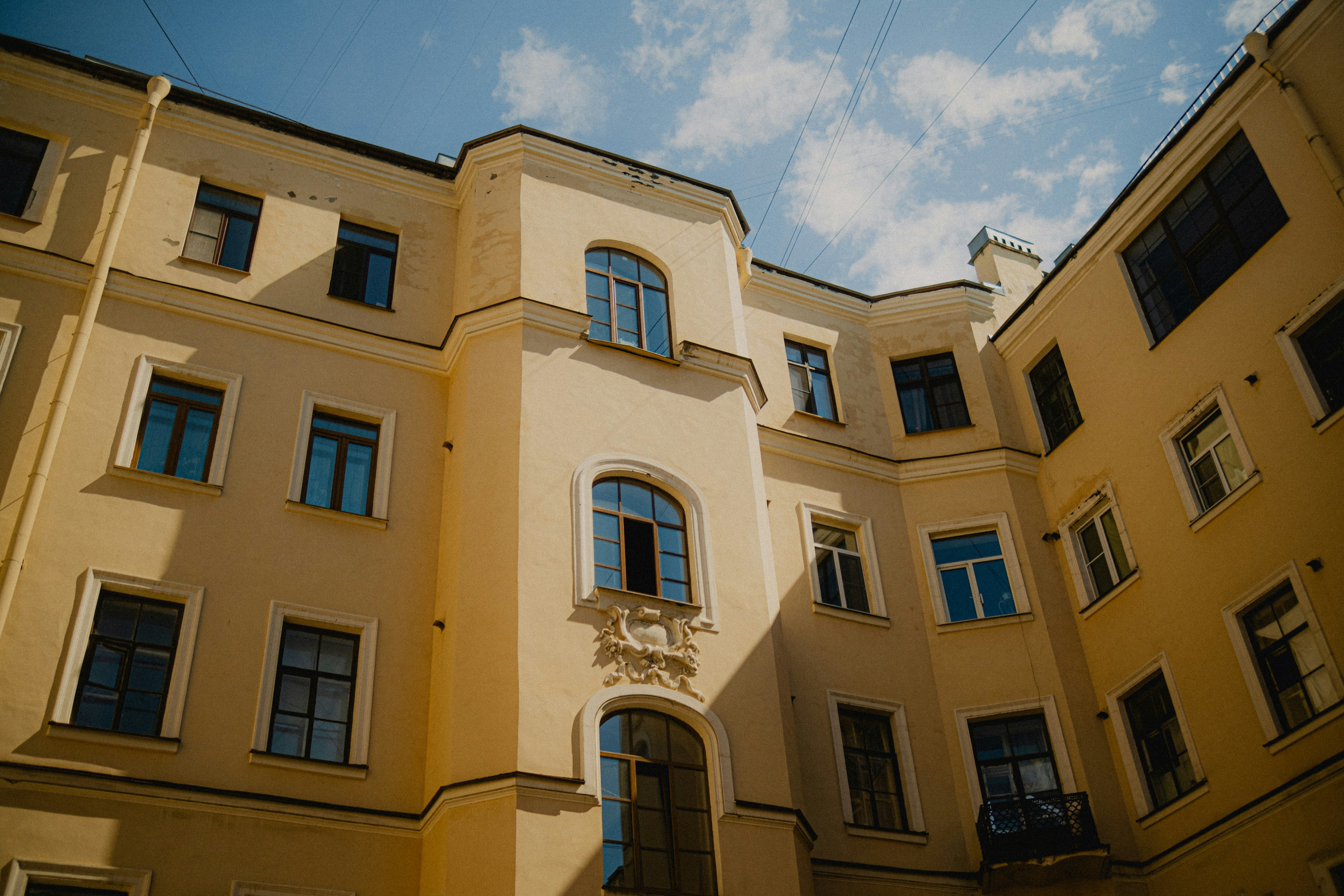 Sunlit Archways: A Corner of Courtyard Pale Yellow
