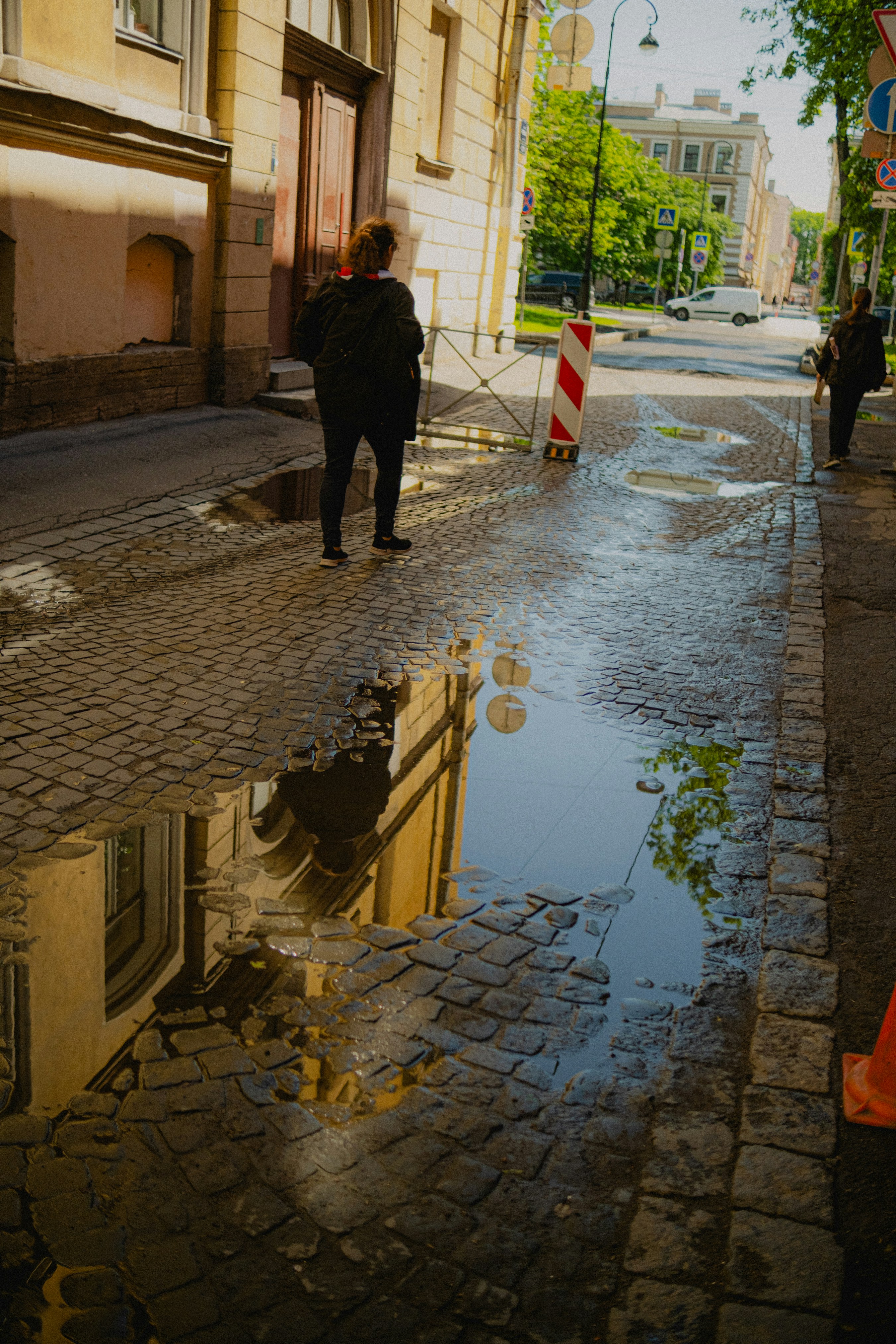 Puddle reflections and cobblestones: a quiet street scene after rain