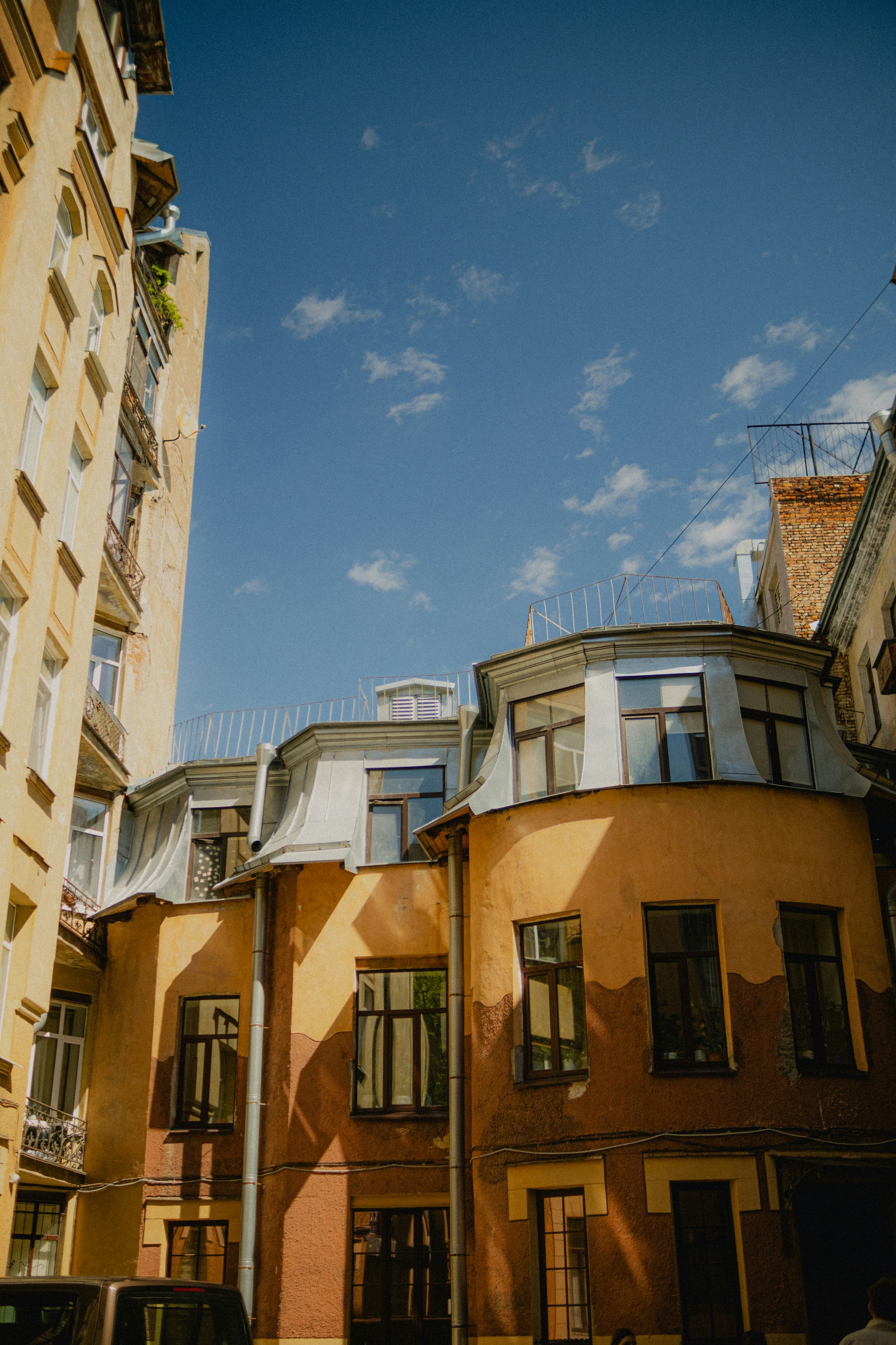 Sunlit Orange Facade: Urban Rooftops Under a Bright Sky