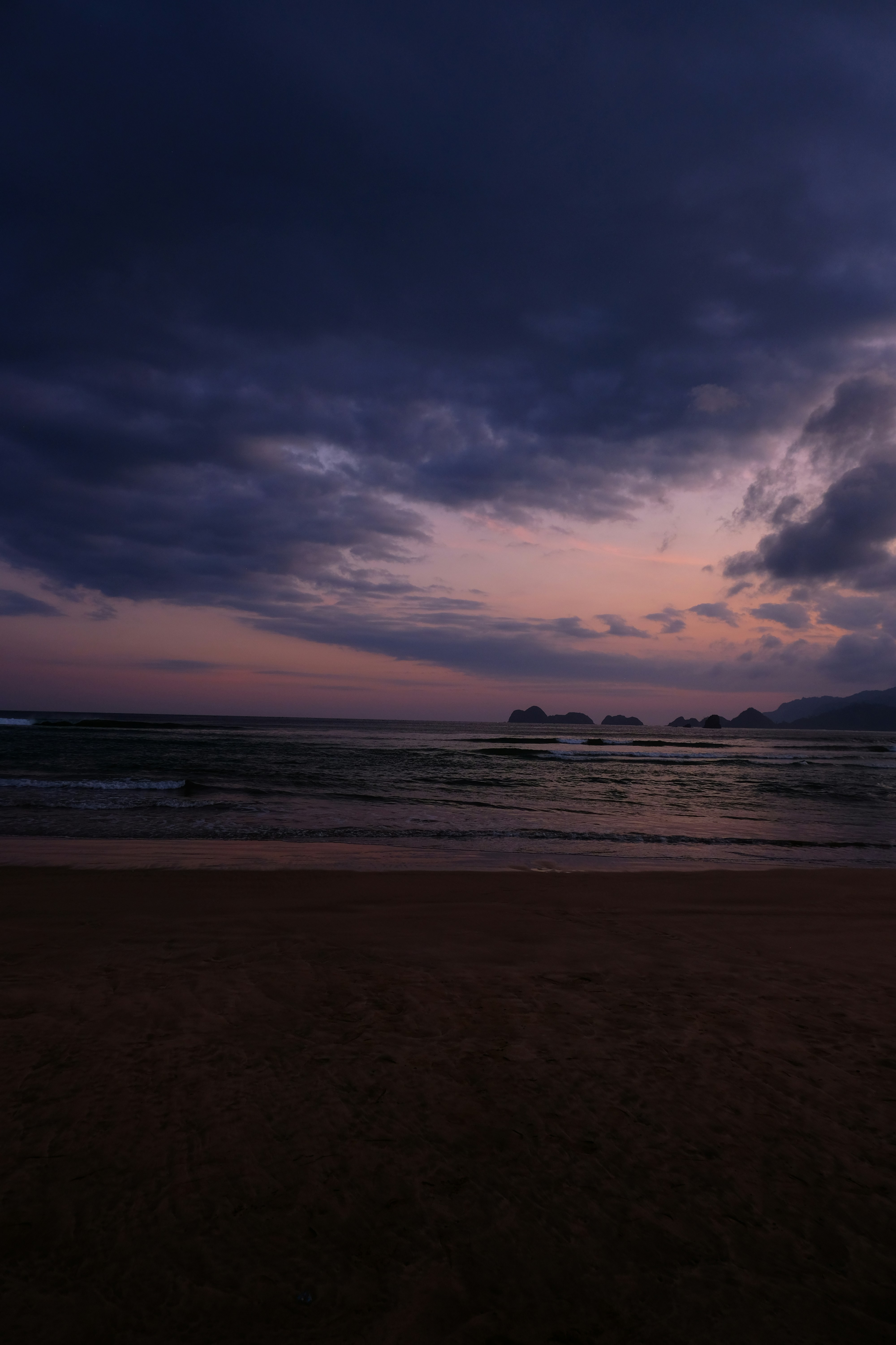 Horizon at Dusk: Quiet Tide Under Brooding Clouds