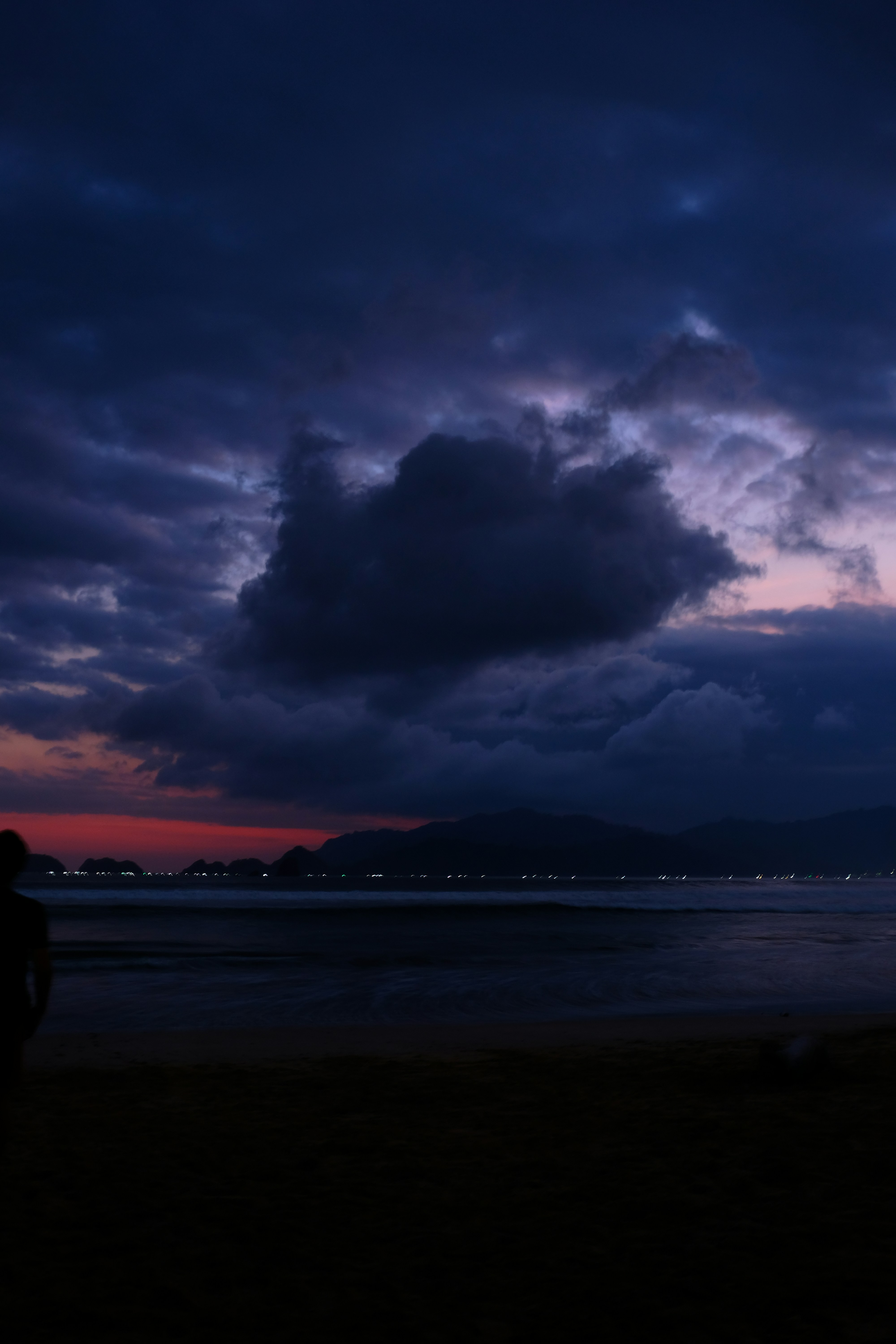 Sunset Over a Quiet Shore Beneath a Looming Cloud