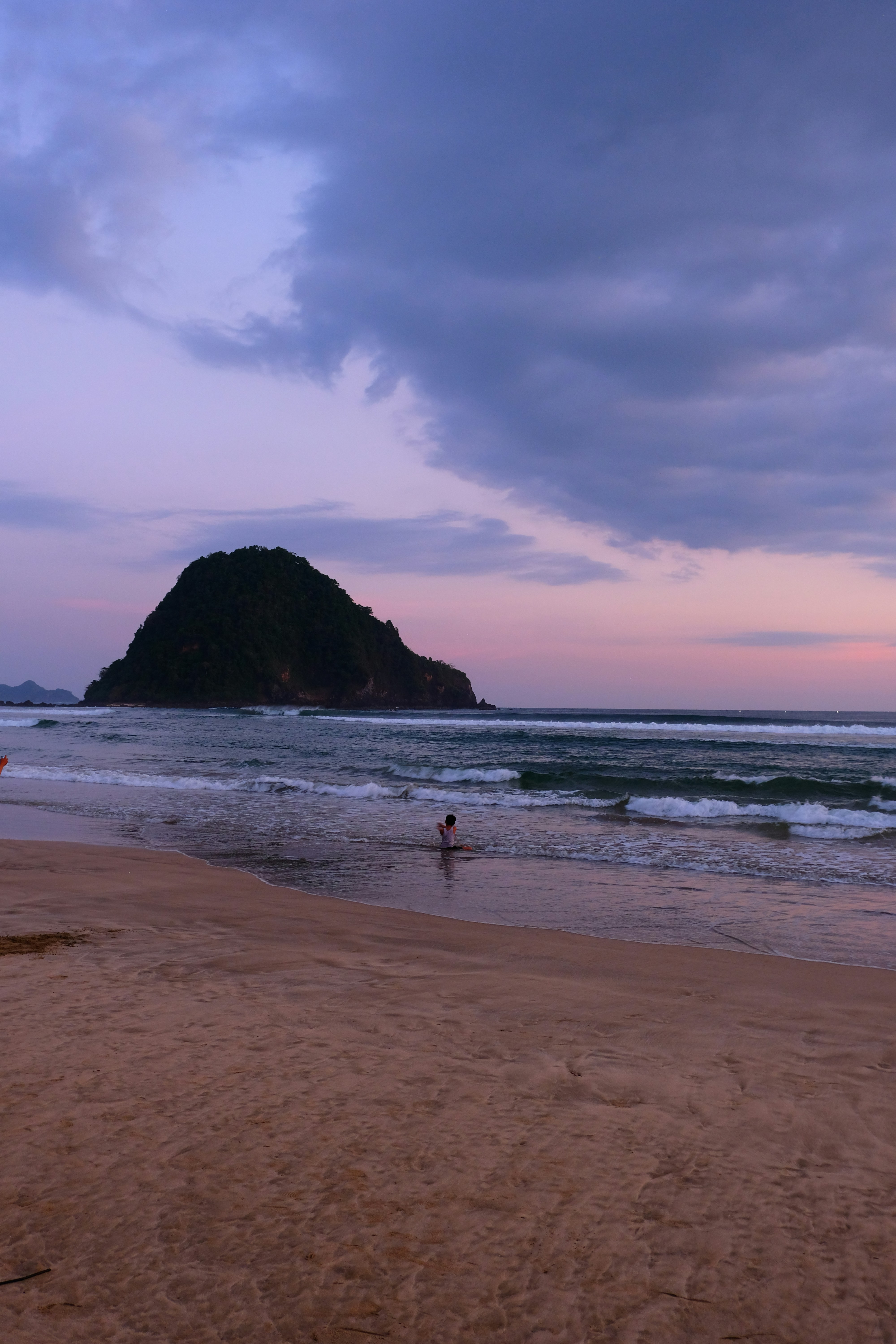 Sunset Silhouette: A Lone Island Embraced by Quiet Waves