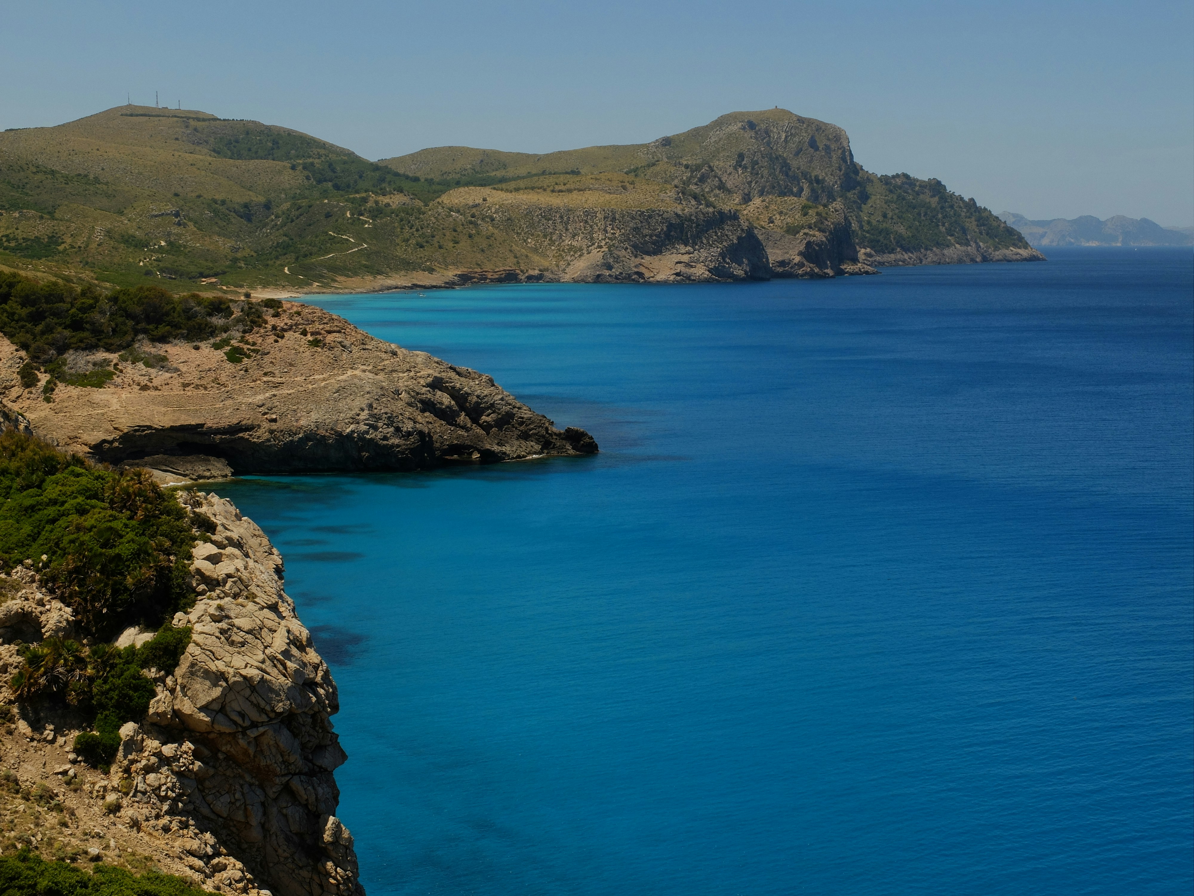 Azure promontory meeting the open sea under a clear horizon