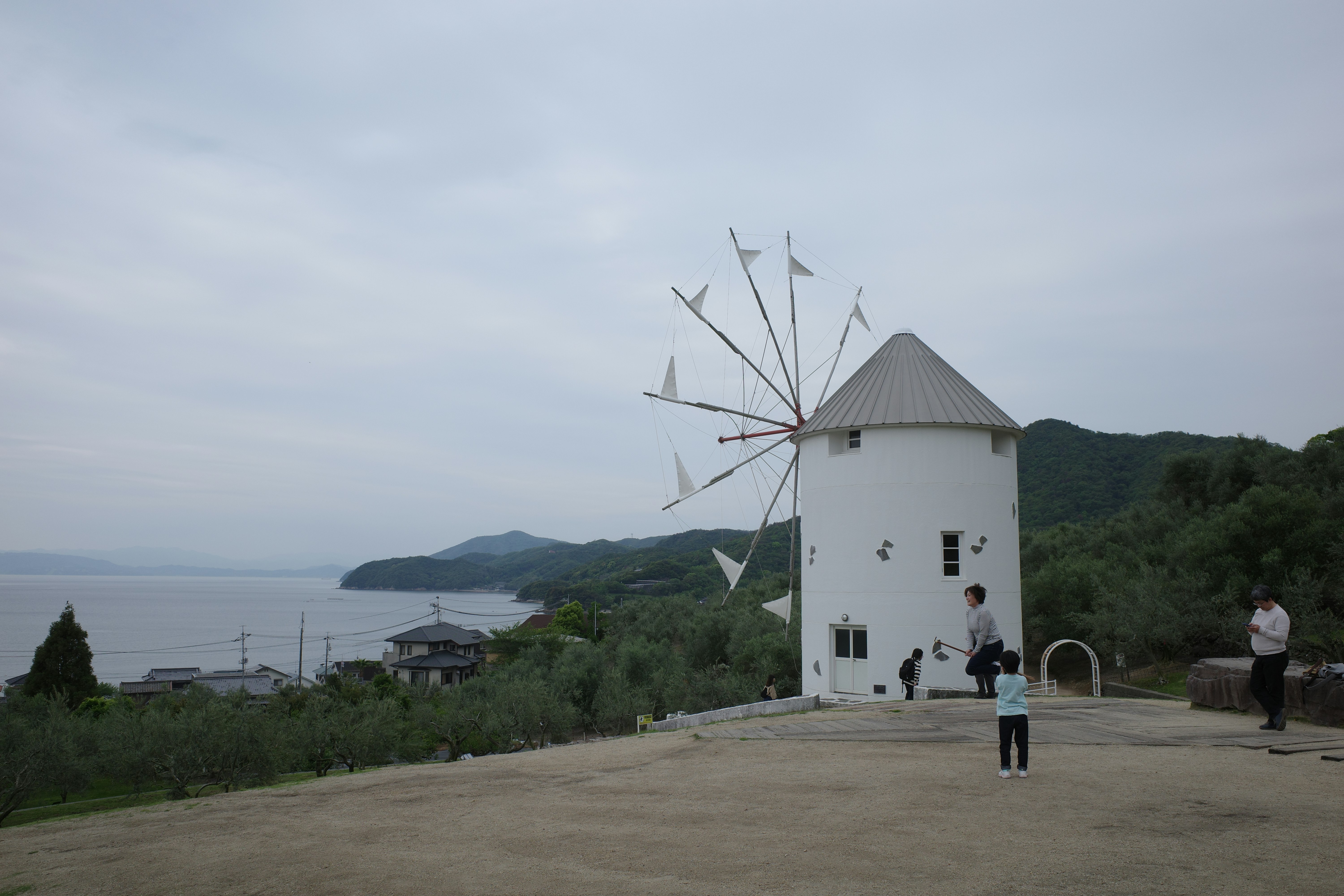Windmill on a coastal hill: quiet scene with visitors