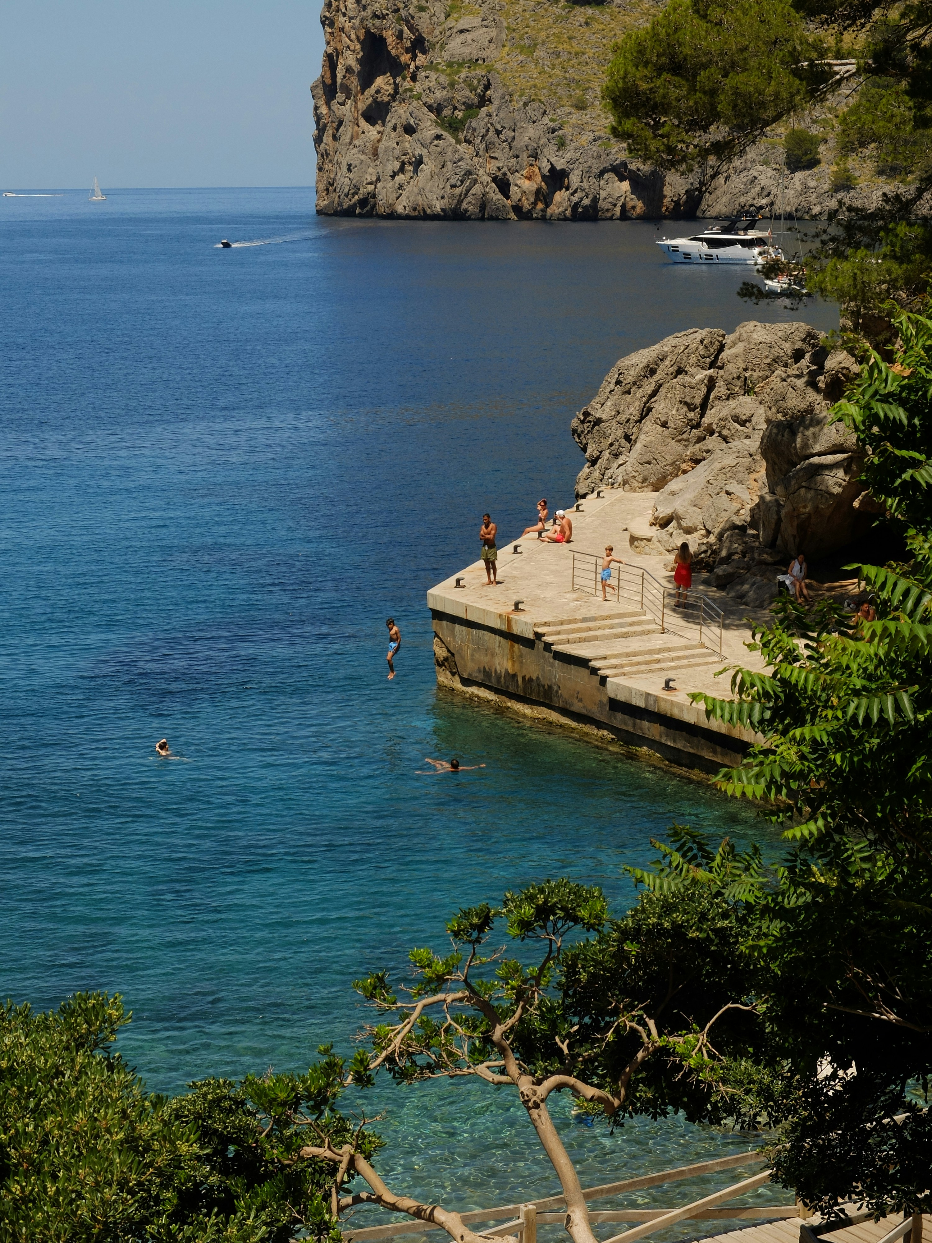Lip of the Cove: People Gather at the Concrete Terrace Over Azure Water