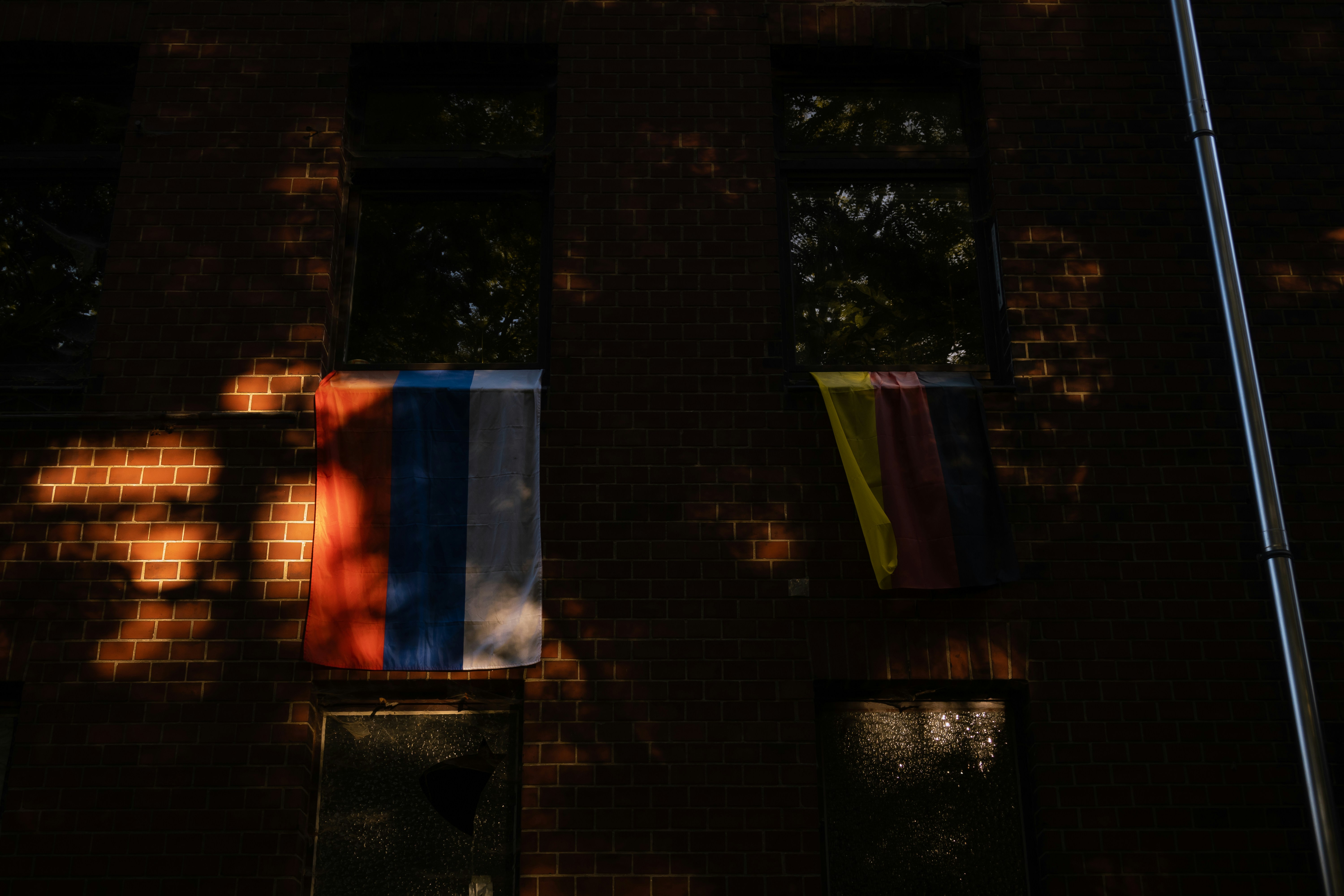 Shadows and Flags on a Brick Facade