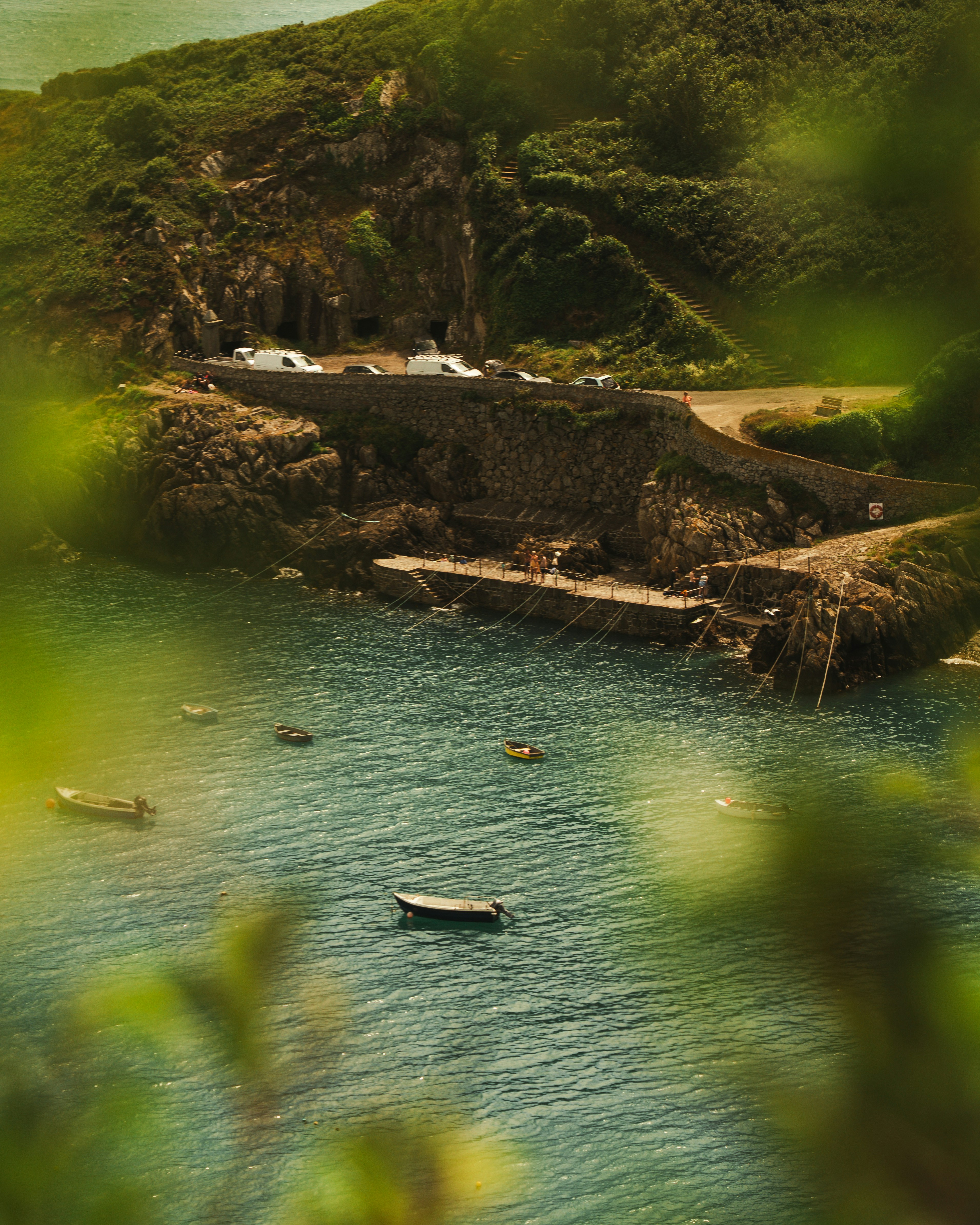 Hidden Cove: Boats Drift in Turquoise Waters Beneath a Cliffside Stair