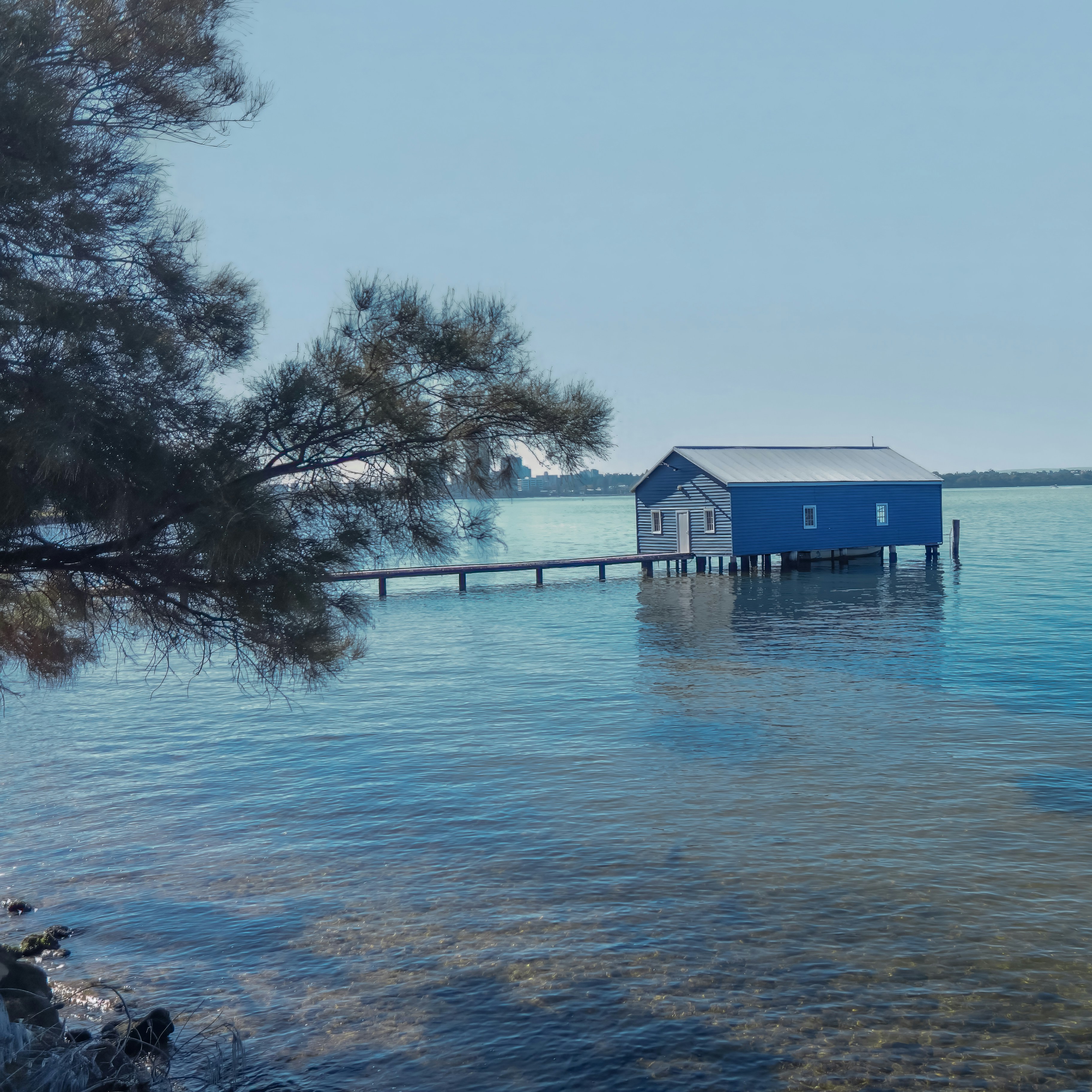 Blue Boathouse on a Quiet Tidal Reach