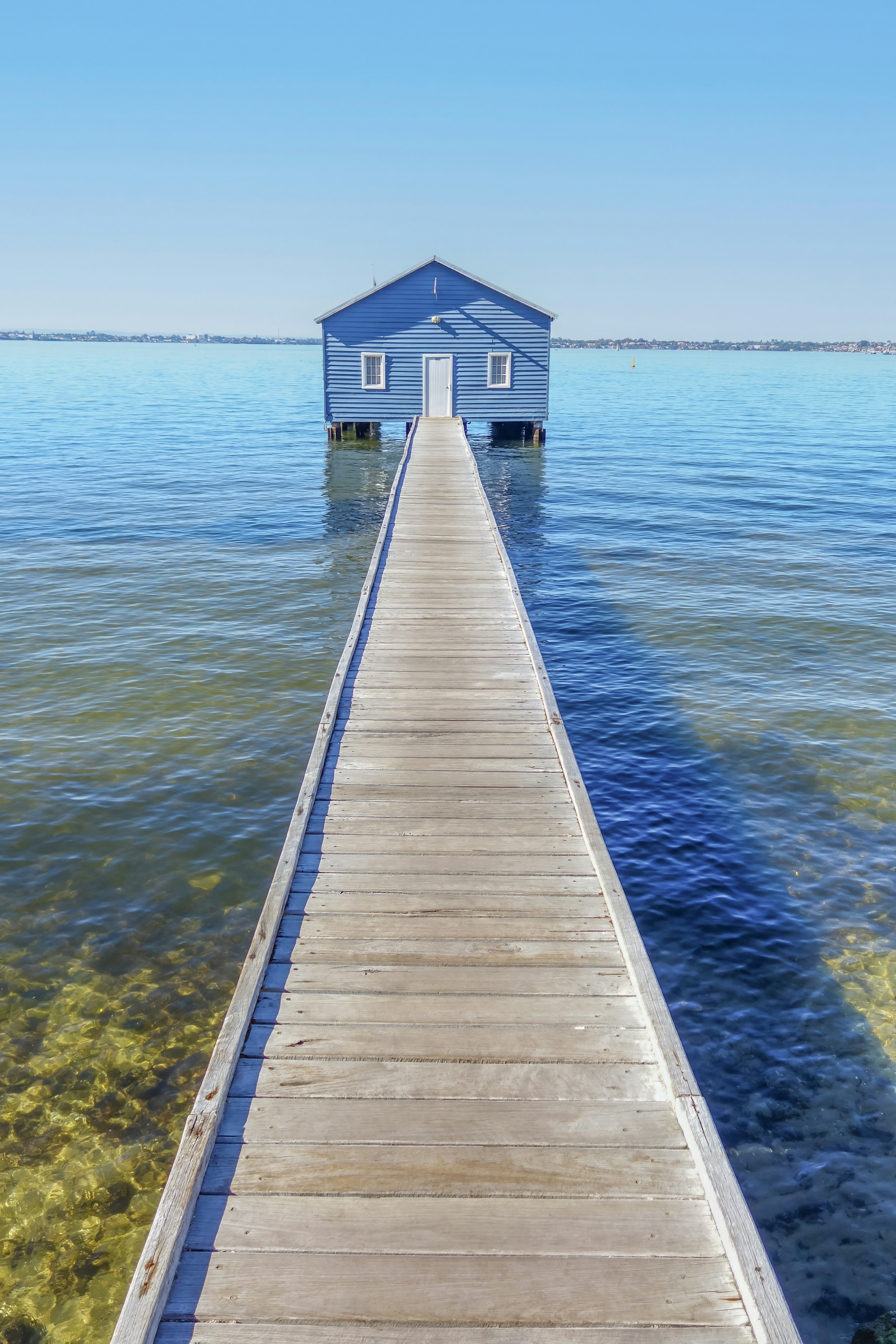 Blue Boathouse at the End of a Wooden Pier