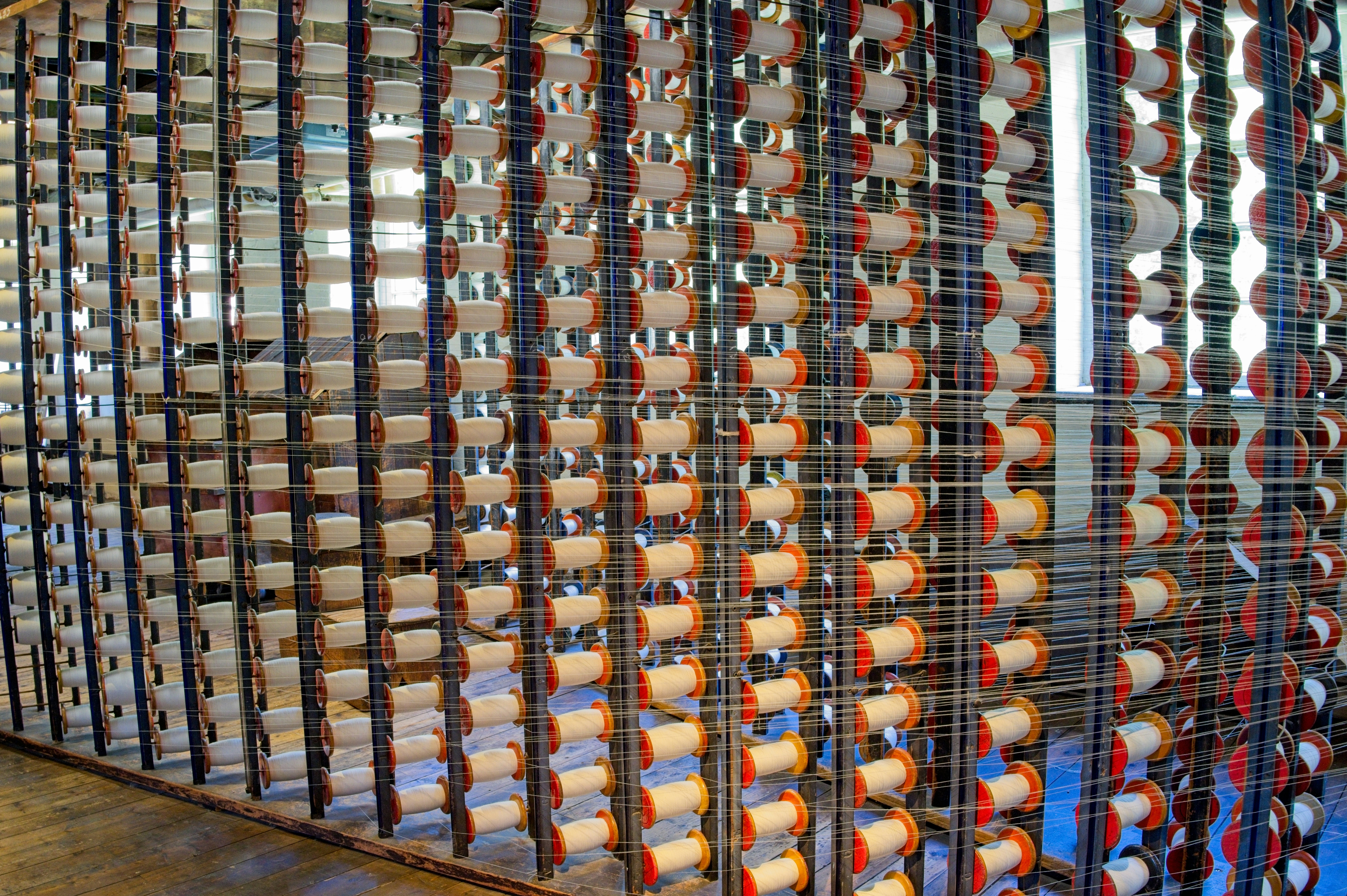 Rows of Colorful Spools: A Warehouse of Curved Ribbons