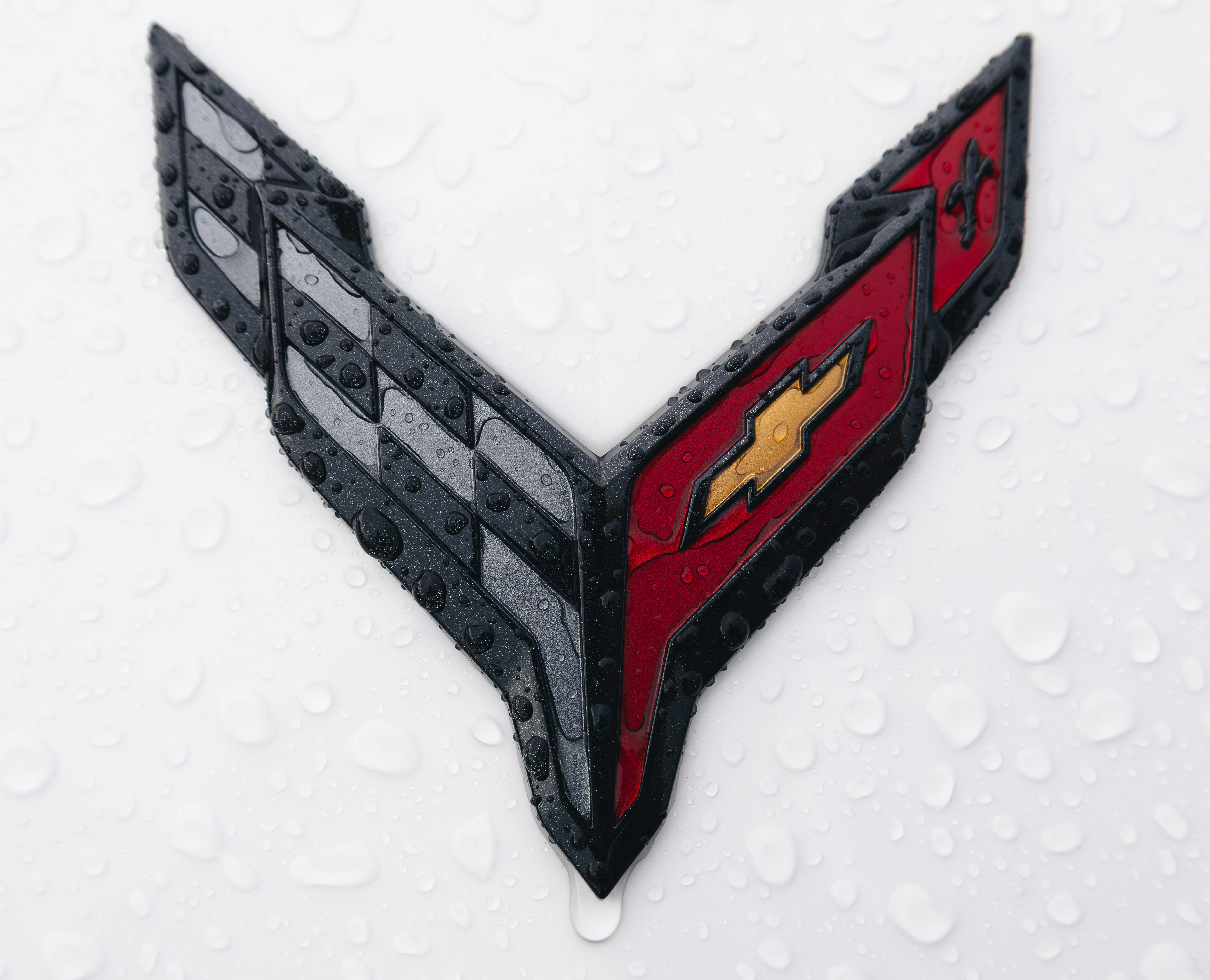 Raindrop-streaked Corvette Emblem: Precision under Glass