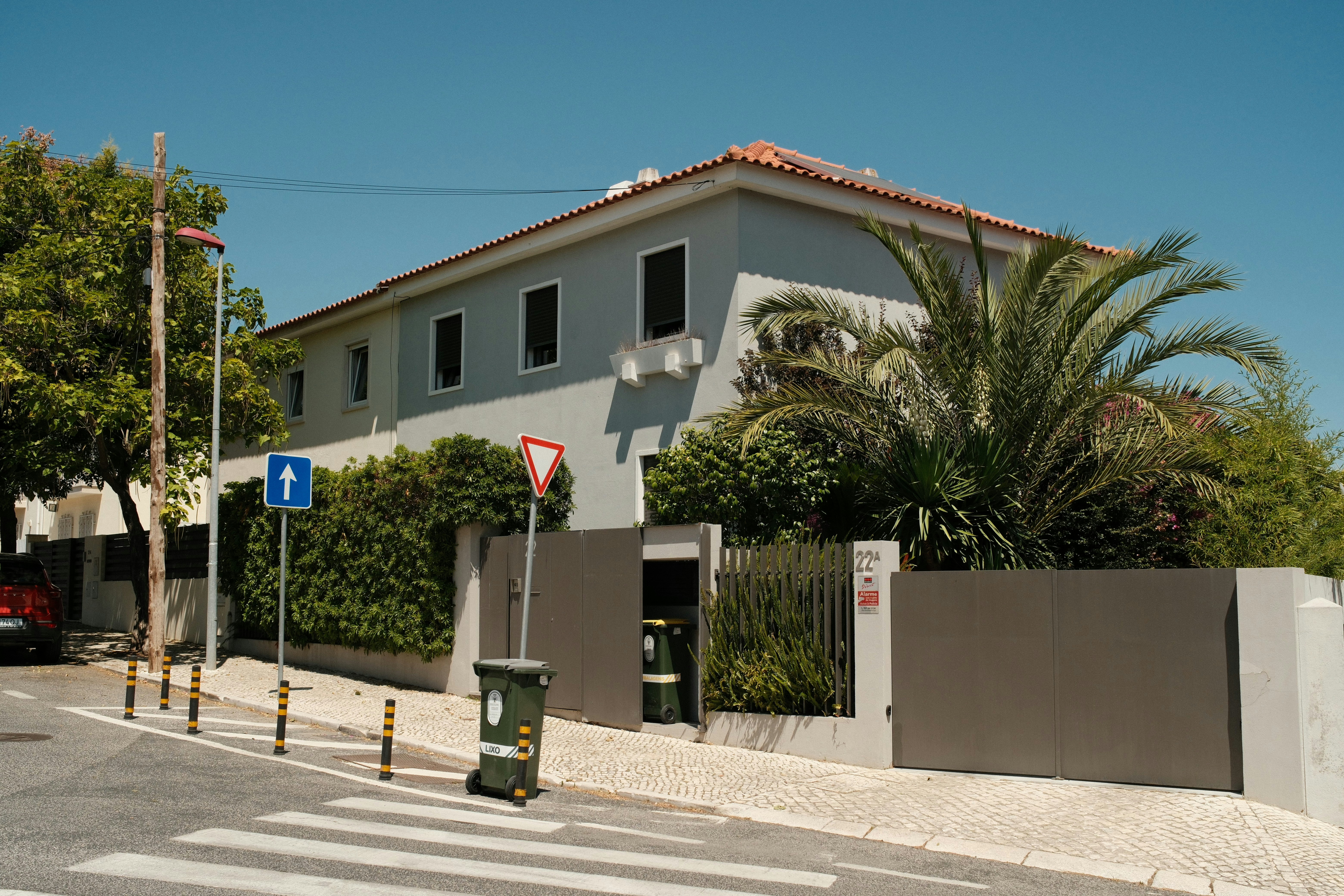 A peaceful residential corner in Benfica, Lisbon, featuring Mediterranean gardens, palm trees, modern homes, and bright summer sunshine that defines suburban Lisbon. Shot with Fujifilm X-M5 // Um recanto residencial tranquilo em Benfica, Lisboa, com jardins mediterrânicos, palmeiras, moradias modernas e a luz intensa do verão que caracteriza a zona suburbana da cidade.