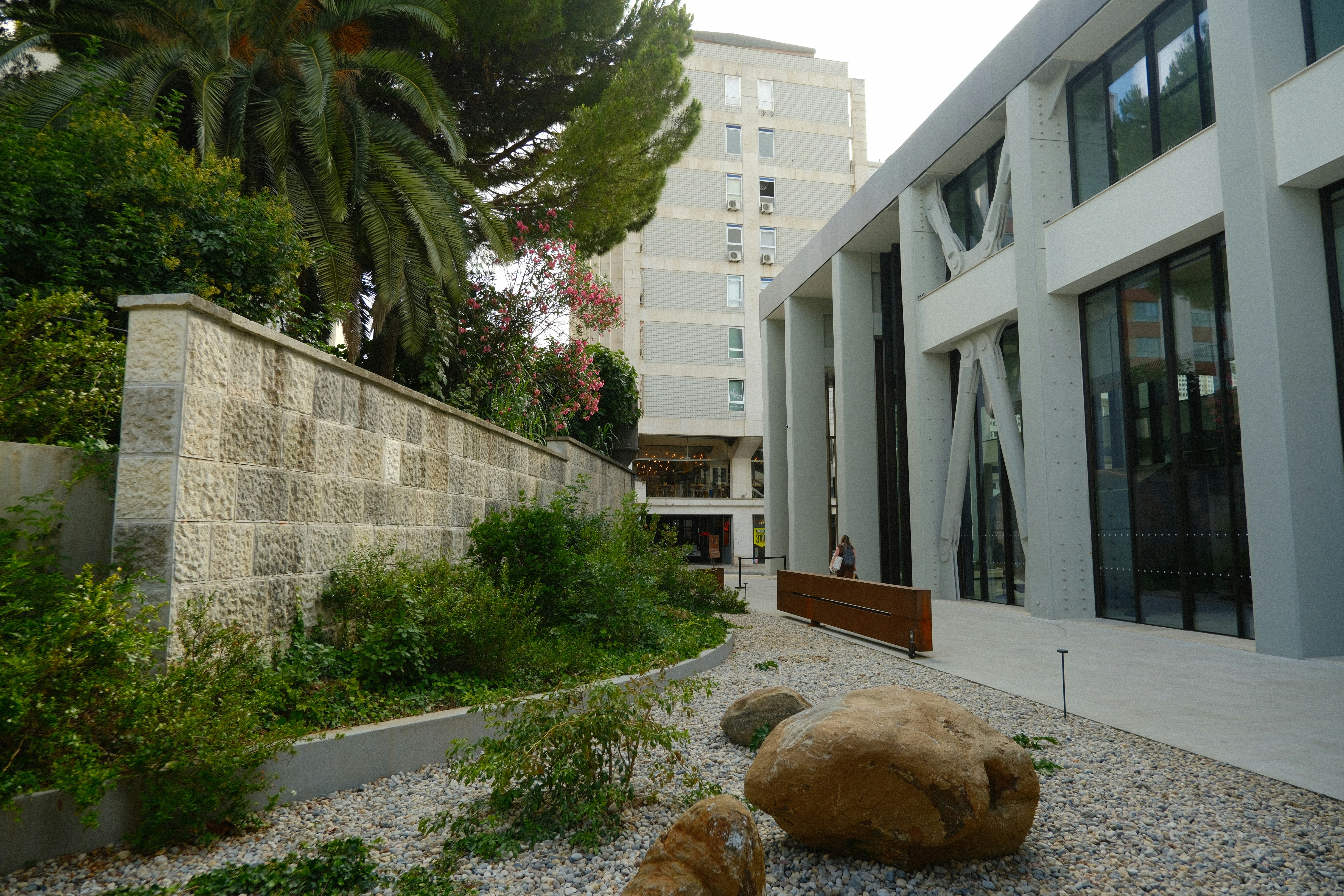 A peaceful view of contemporary architecture surrounded by mature trees and landscaped gardens inside Gulbenkian Park, Lisbon, highlighting the harmony between modern construction and nature. Shot with Fujifilm X-M5 // Uma vista tranquila da arquitetura contemporânea rodeada por árvores maduras e jardins cuidadosamente desenhados no Jardim Gulbenkian, em Lisboa, evidenciando a harmonia entre construção moderna e natureza.