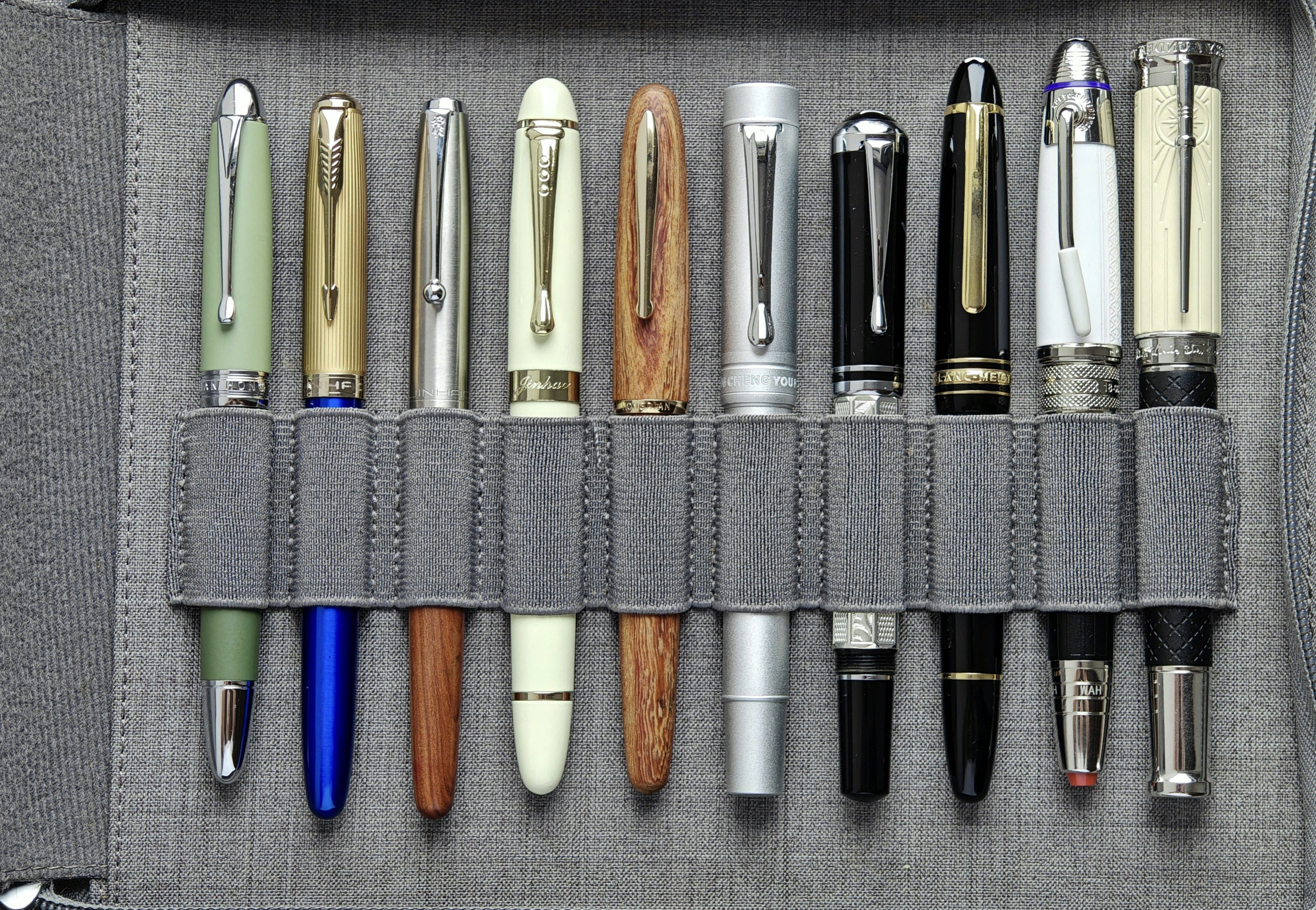 Array of Elegance: A Row of Fountain Pens Resting in a Gray Case