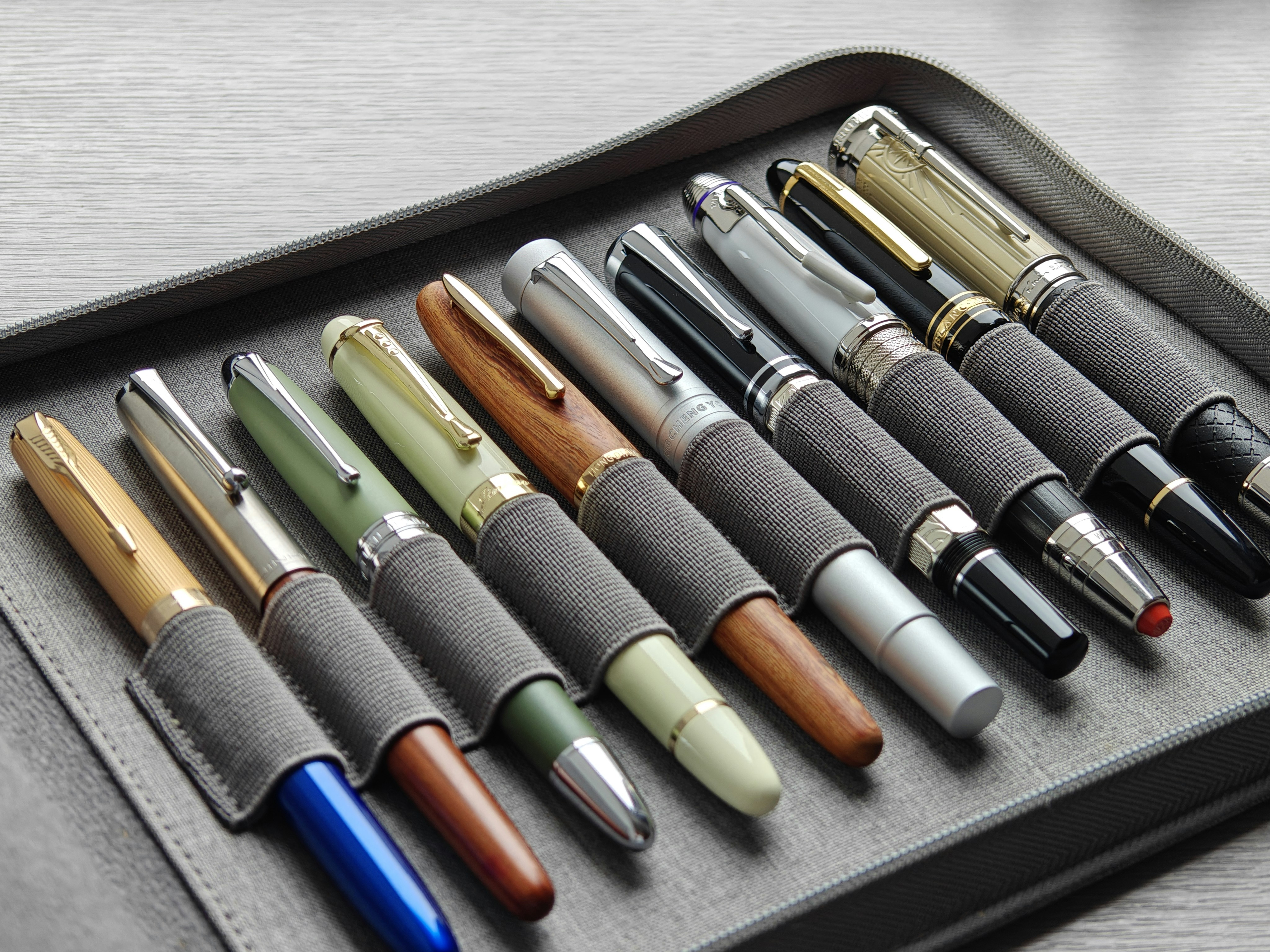 Row of premium fountain pens in a leather roll-up case