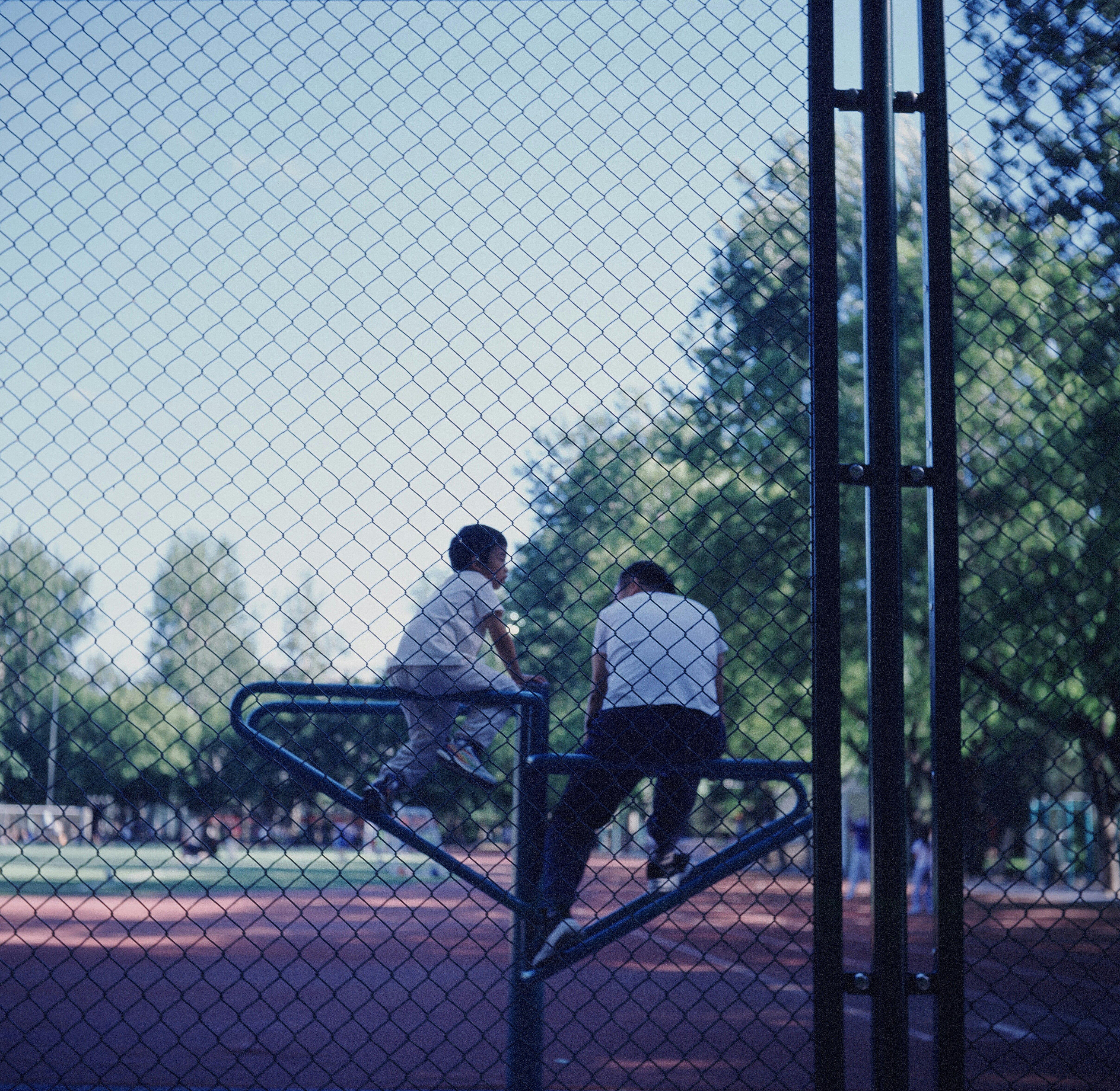 Silhouettes against the chain-link: a quiet moment atop the park’s observation perch