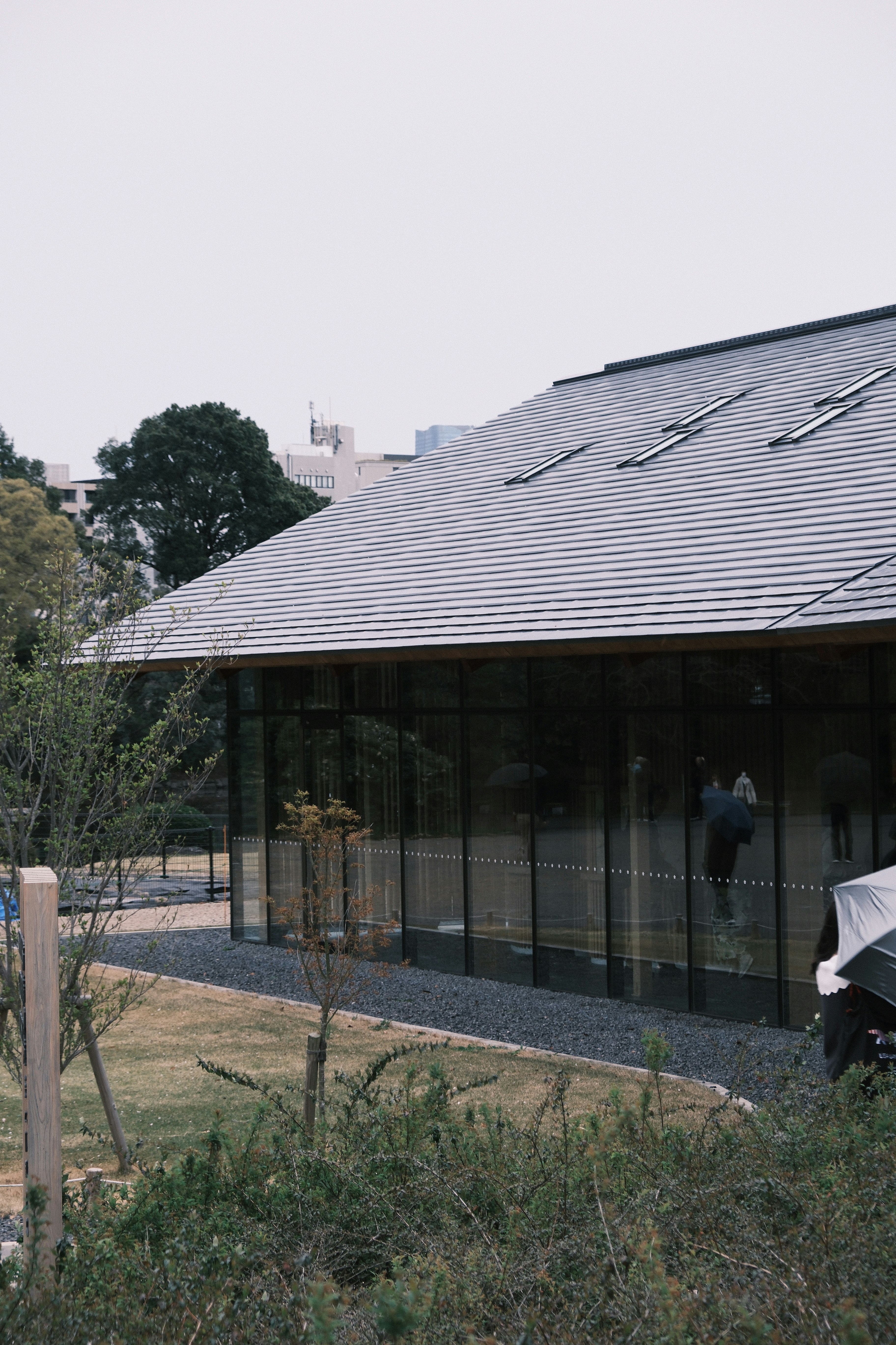 Glass Facade and Sloped Roof: Quiet Urban Corner