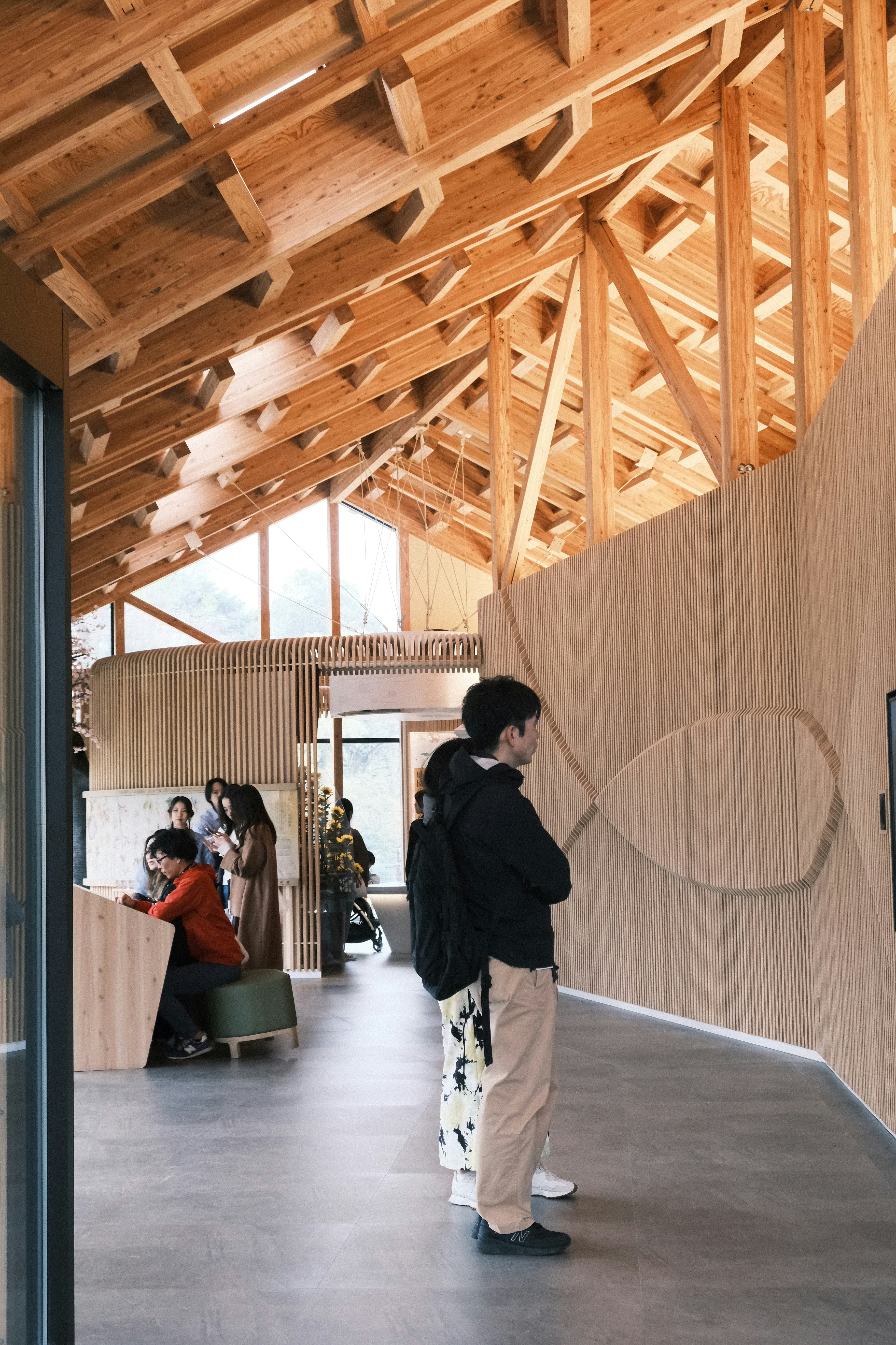 Wooden Architecture and Visitors: A Quiet Moment Inside a Modern Gallery