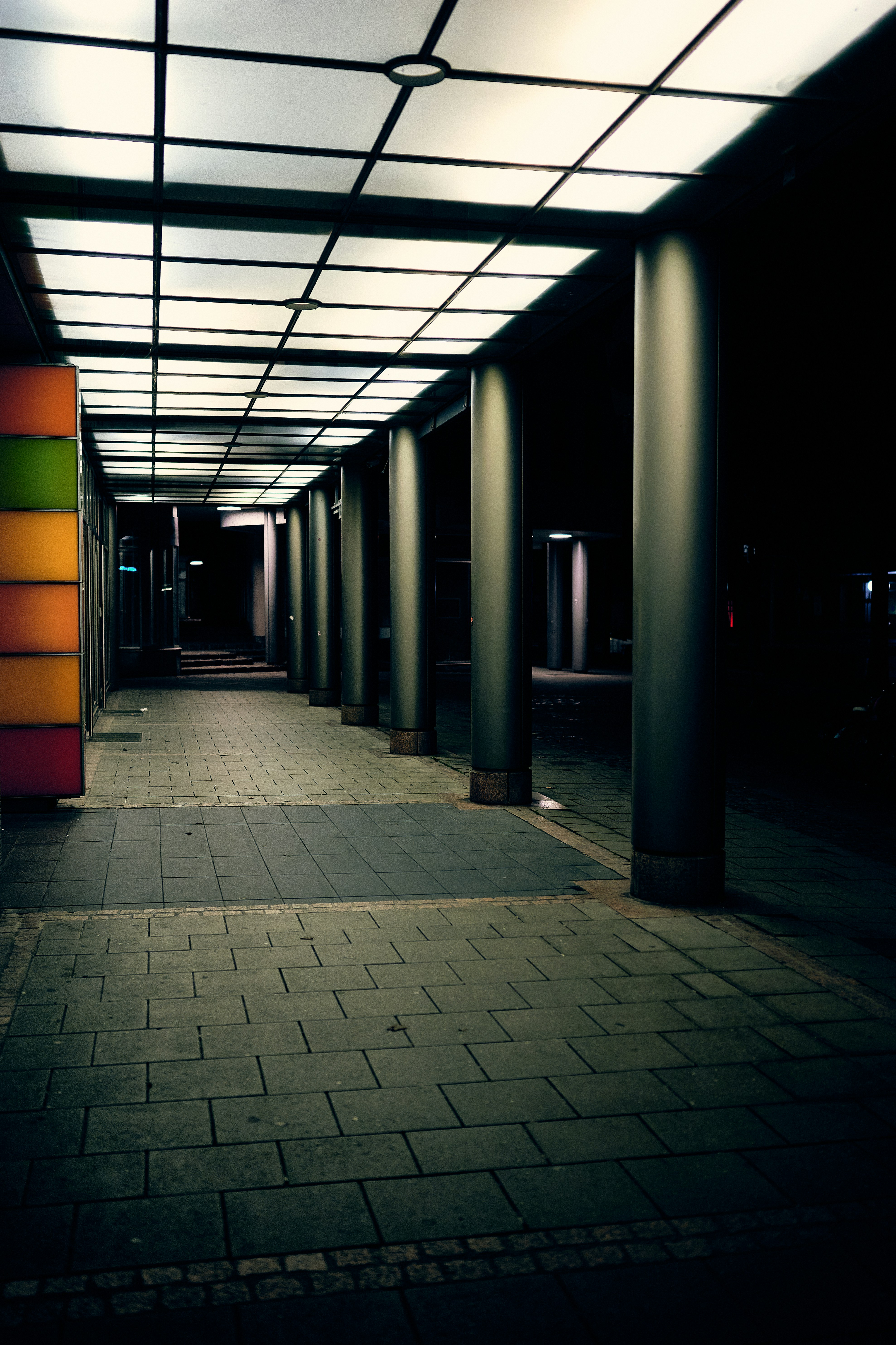Neon Passage: Evening Columns Under a Grid of Light