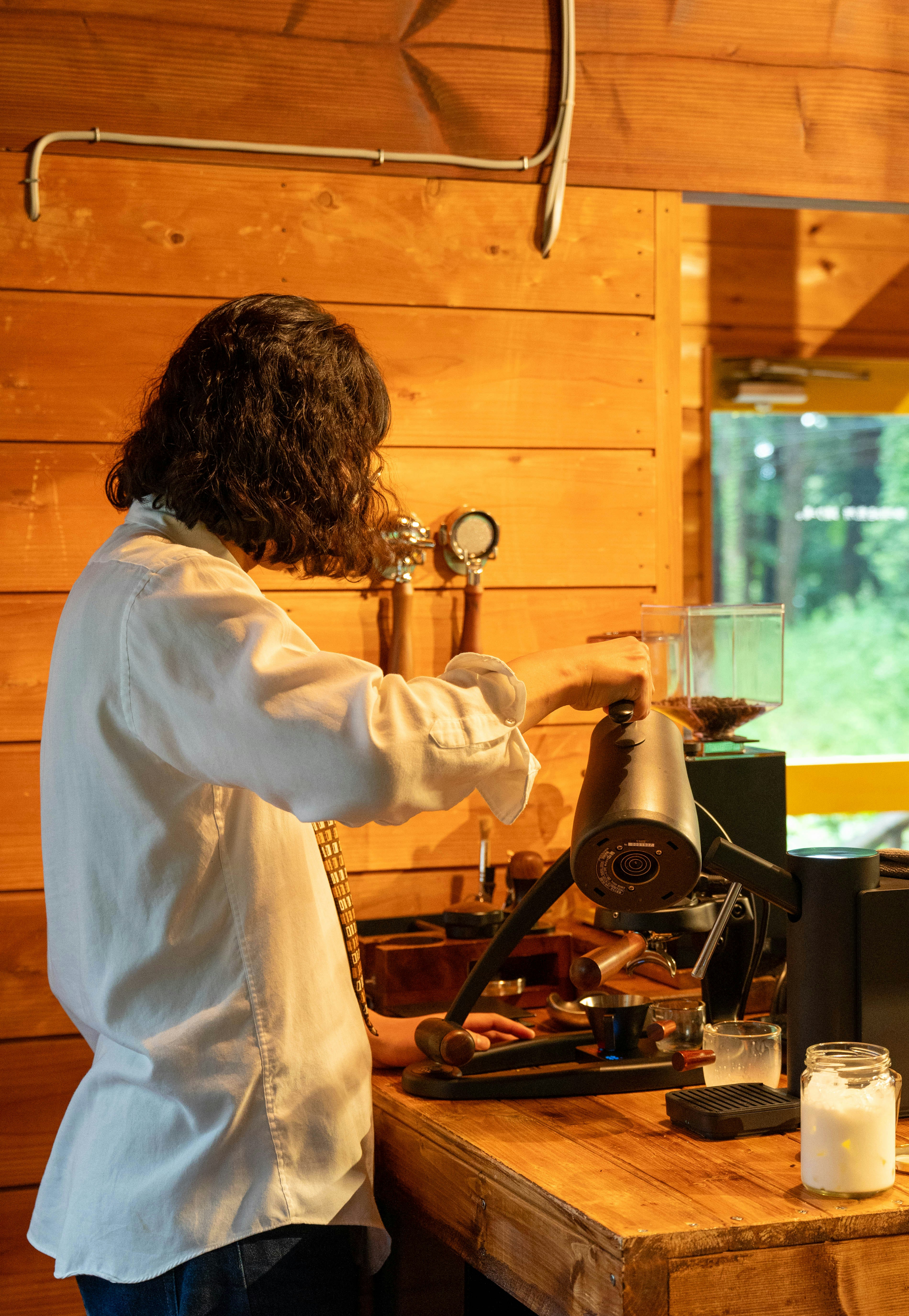 Barista at Work: Crafting Espresso under Warm Cedar Light