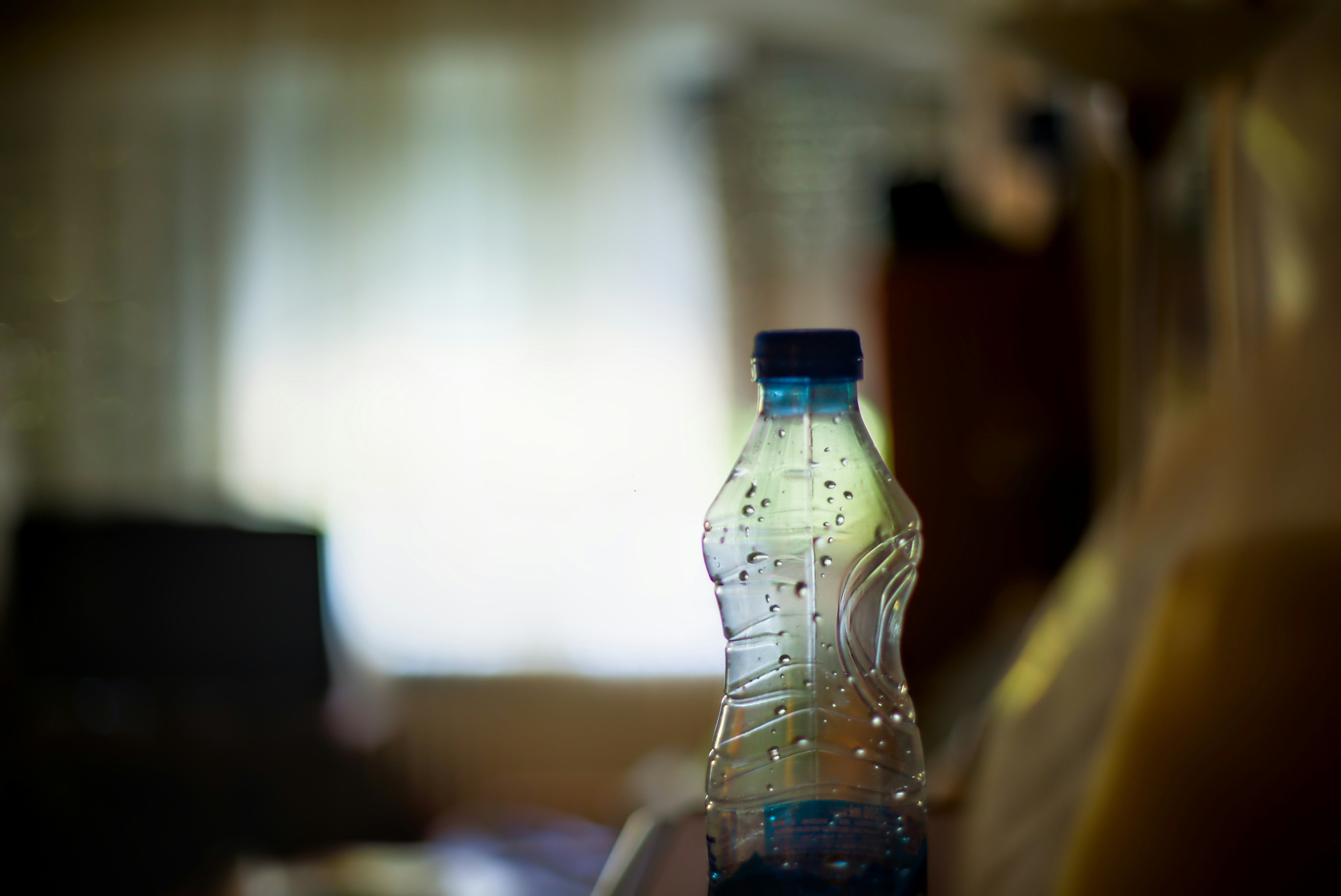 Capped by Blue: A Water Bottle in Quiet Backlight