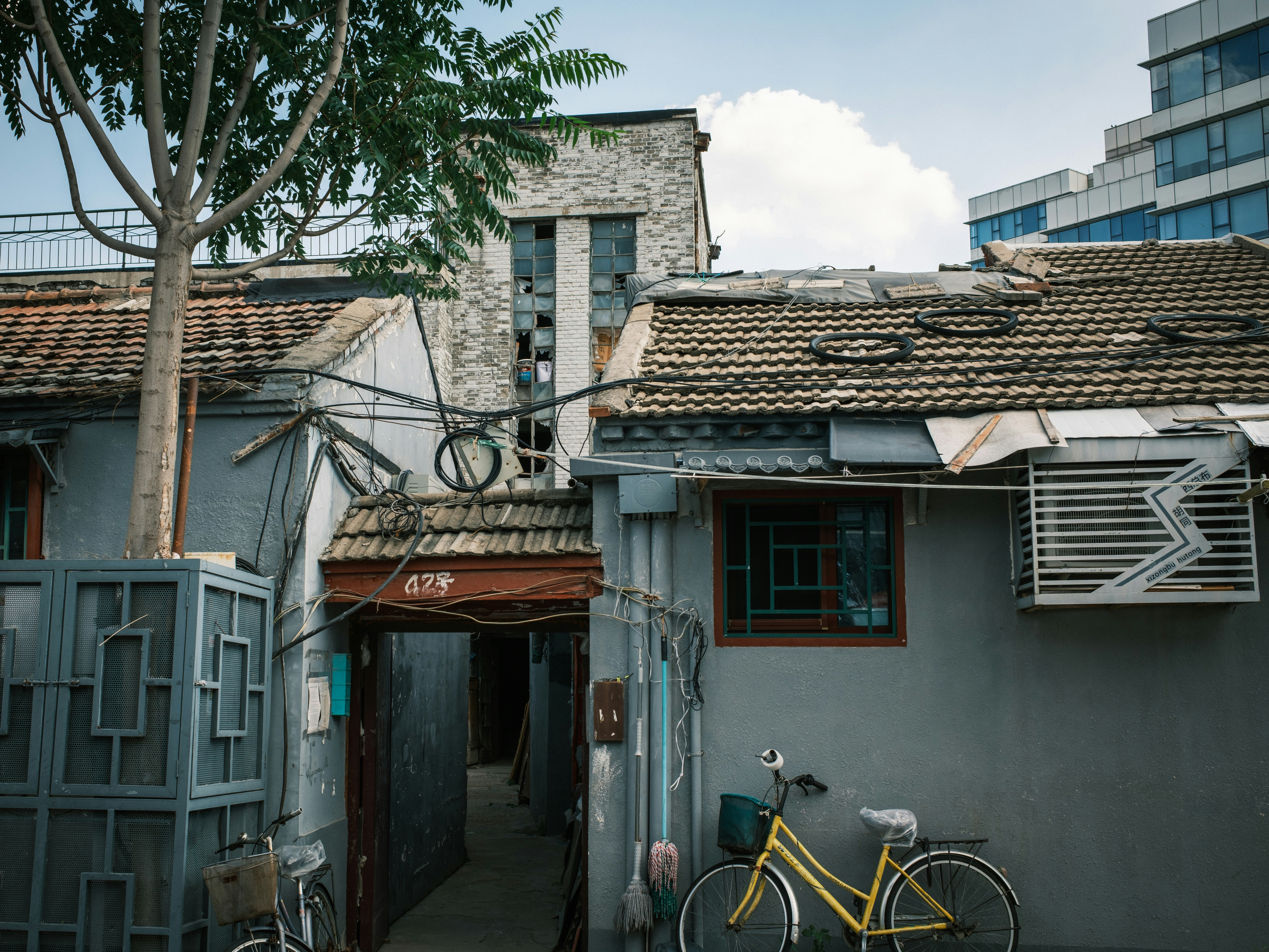 Narrow Alleyway Between Dwellings Under a Sunlit Sky