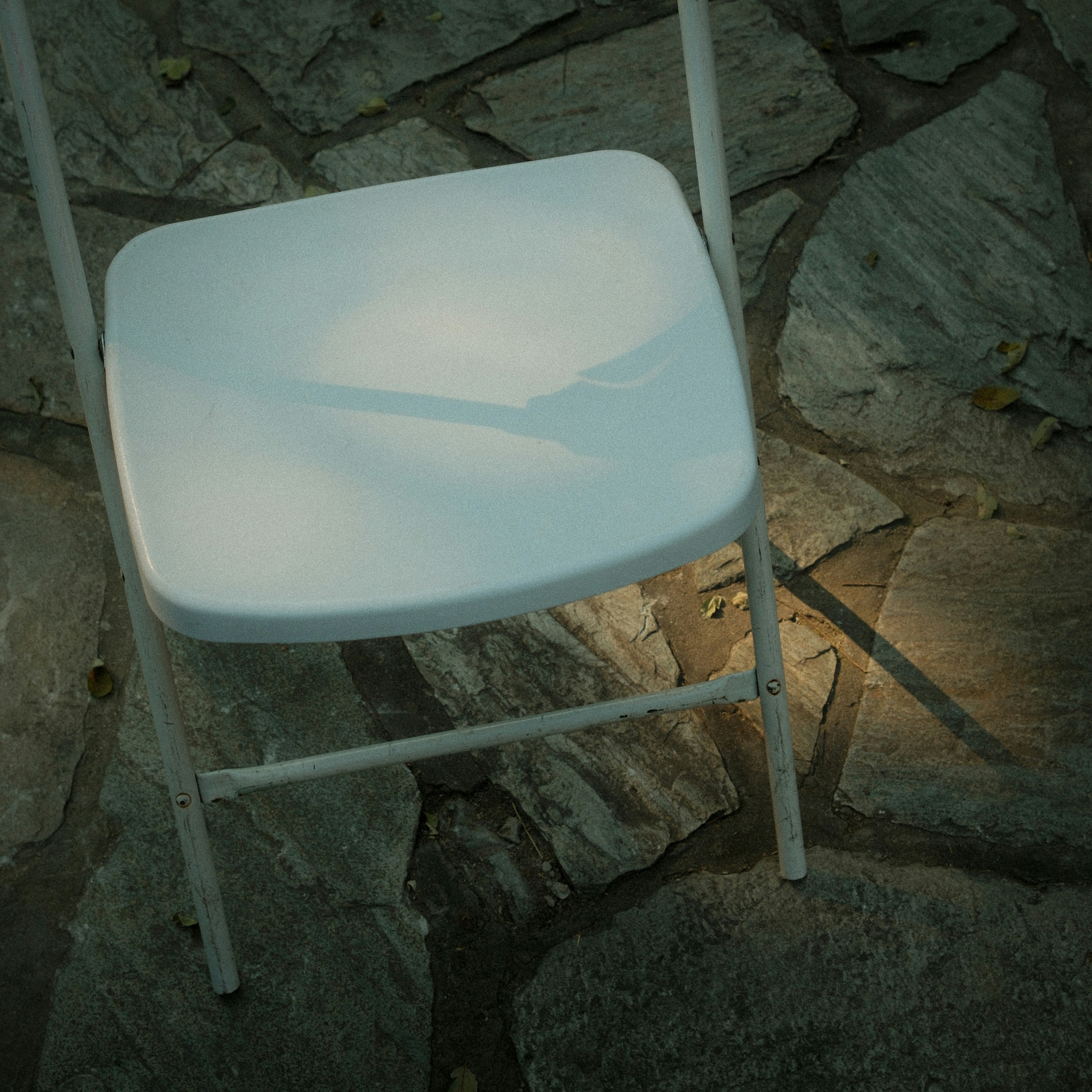 Pastel Seat, Stark Shadows: A Quiet Corner of Stone and Steel