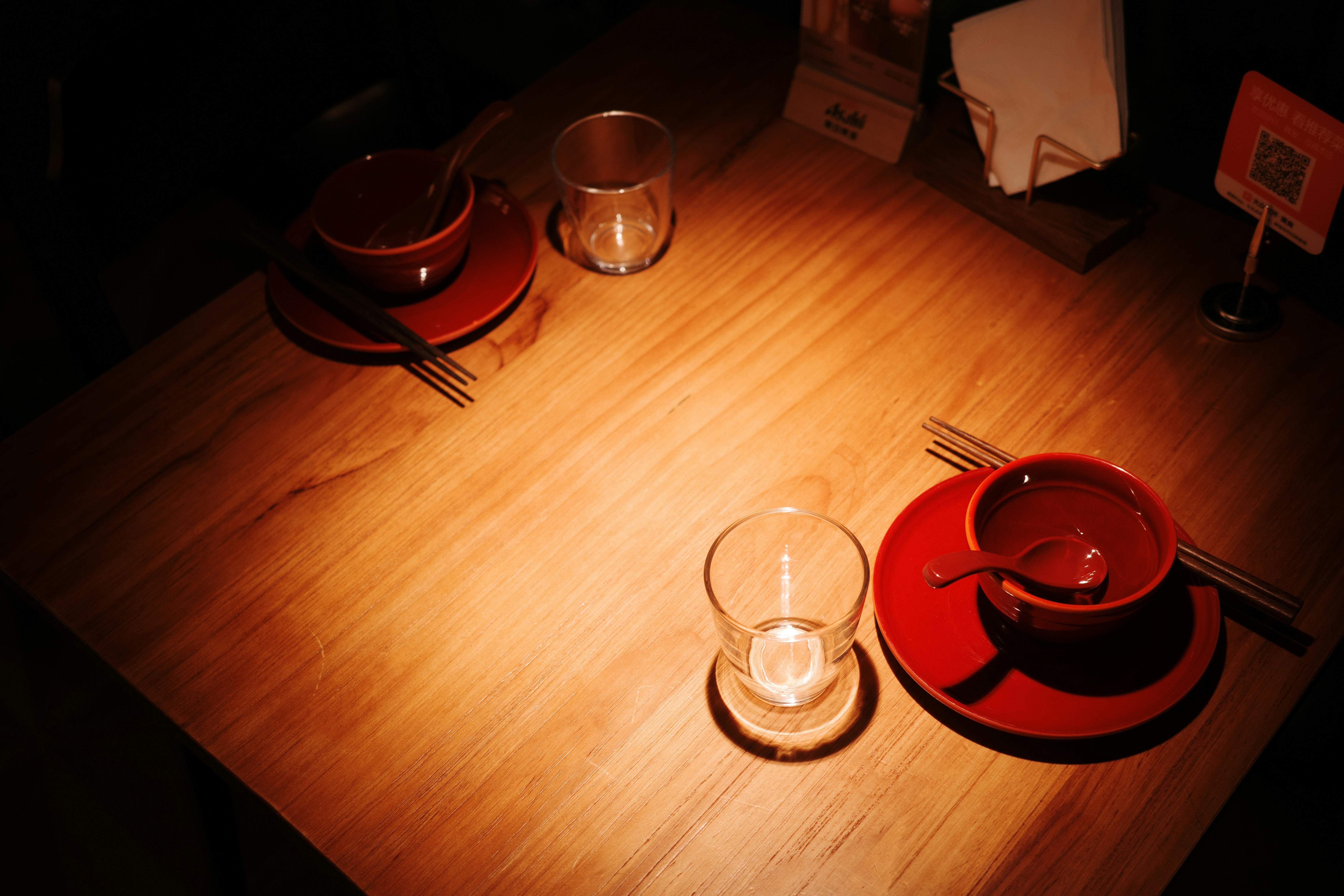 Dimly Lit Dinner: Minimalist Table with Red Dinnerware