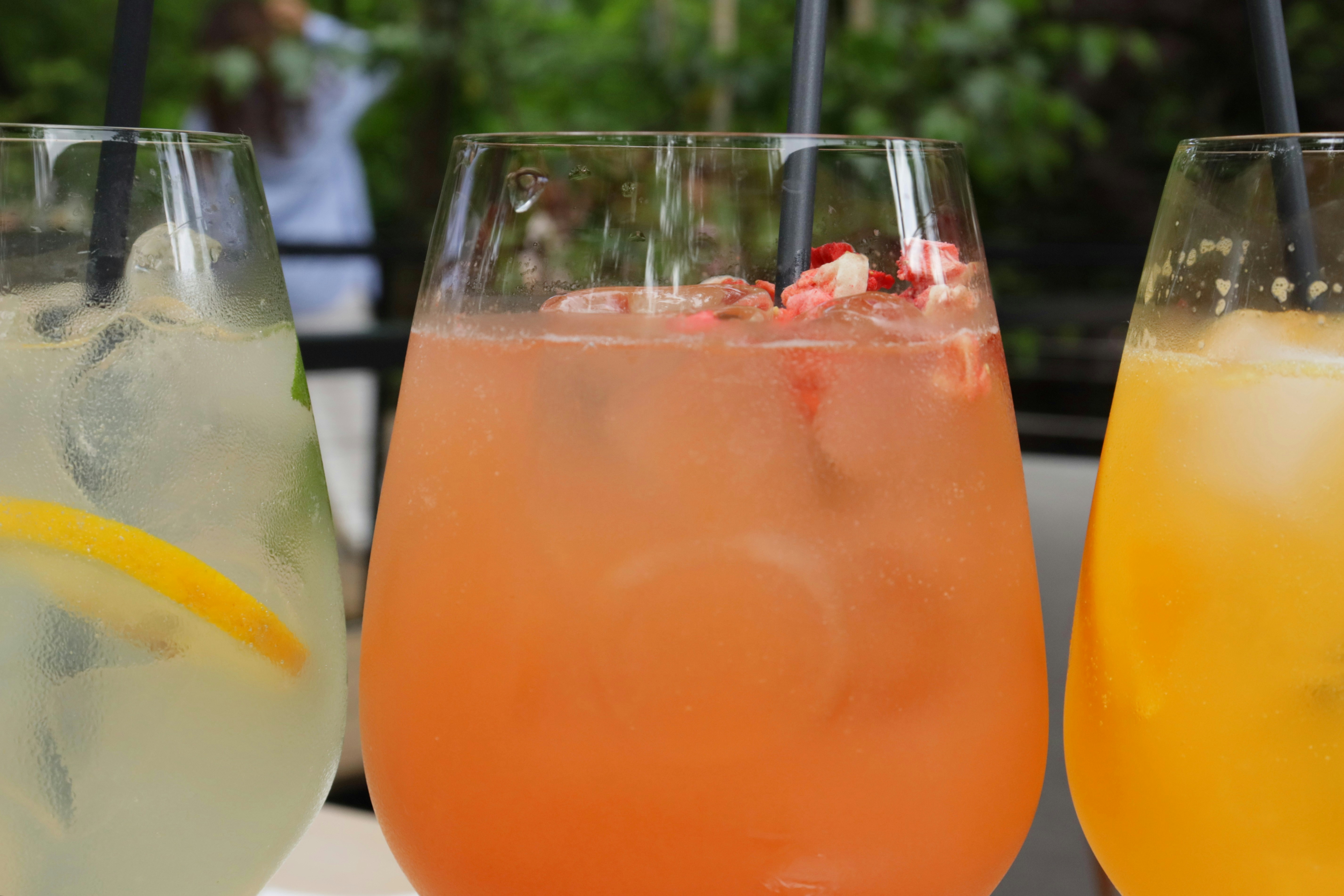 Three Citrus Spritzes on a Sunny Table
