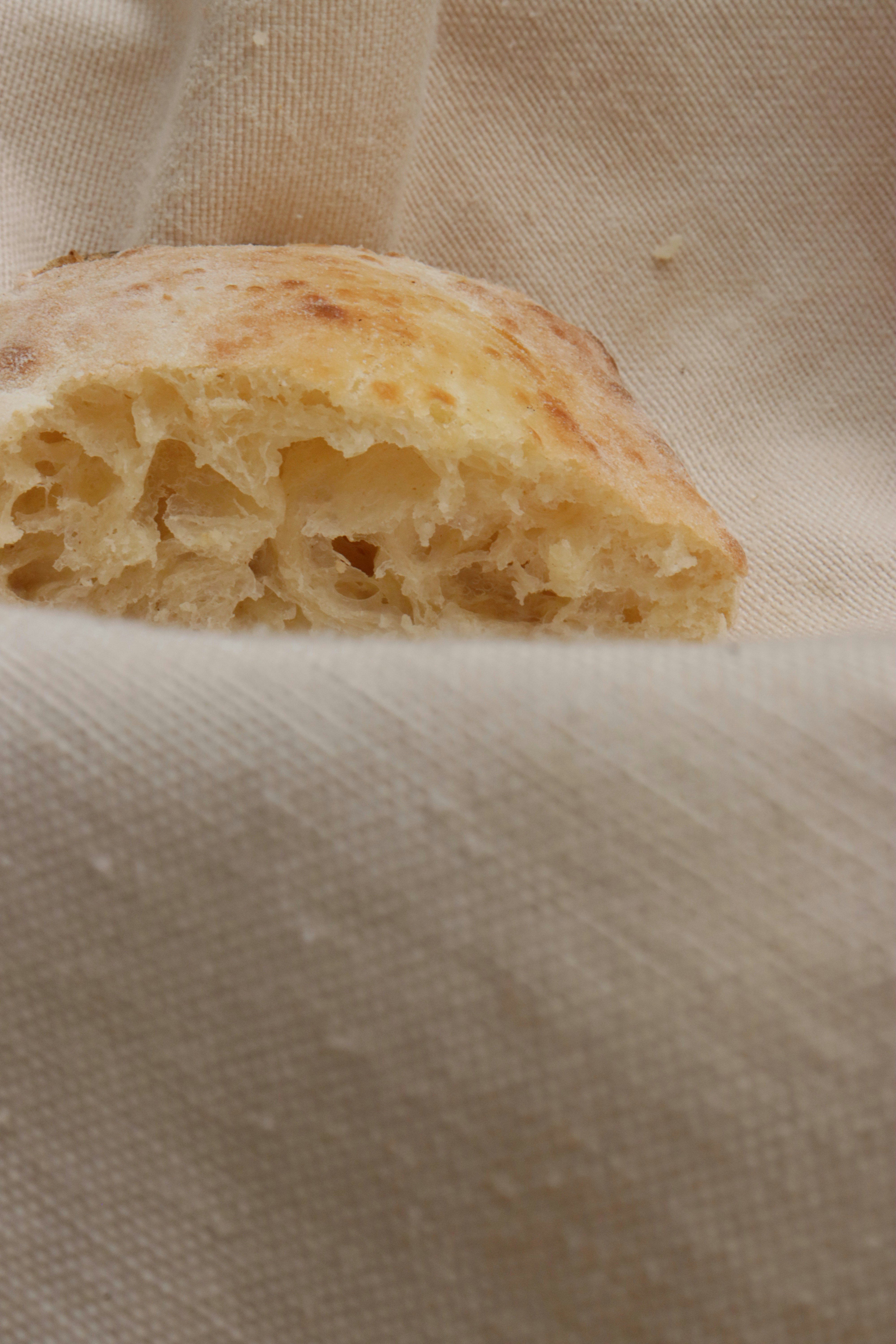 Crusty white bread peeking from a linen drape