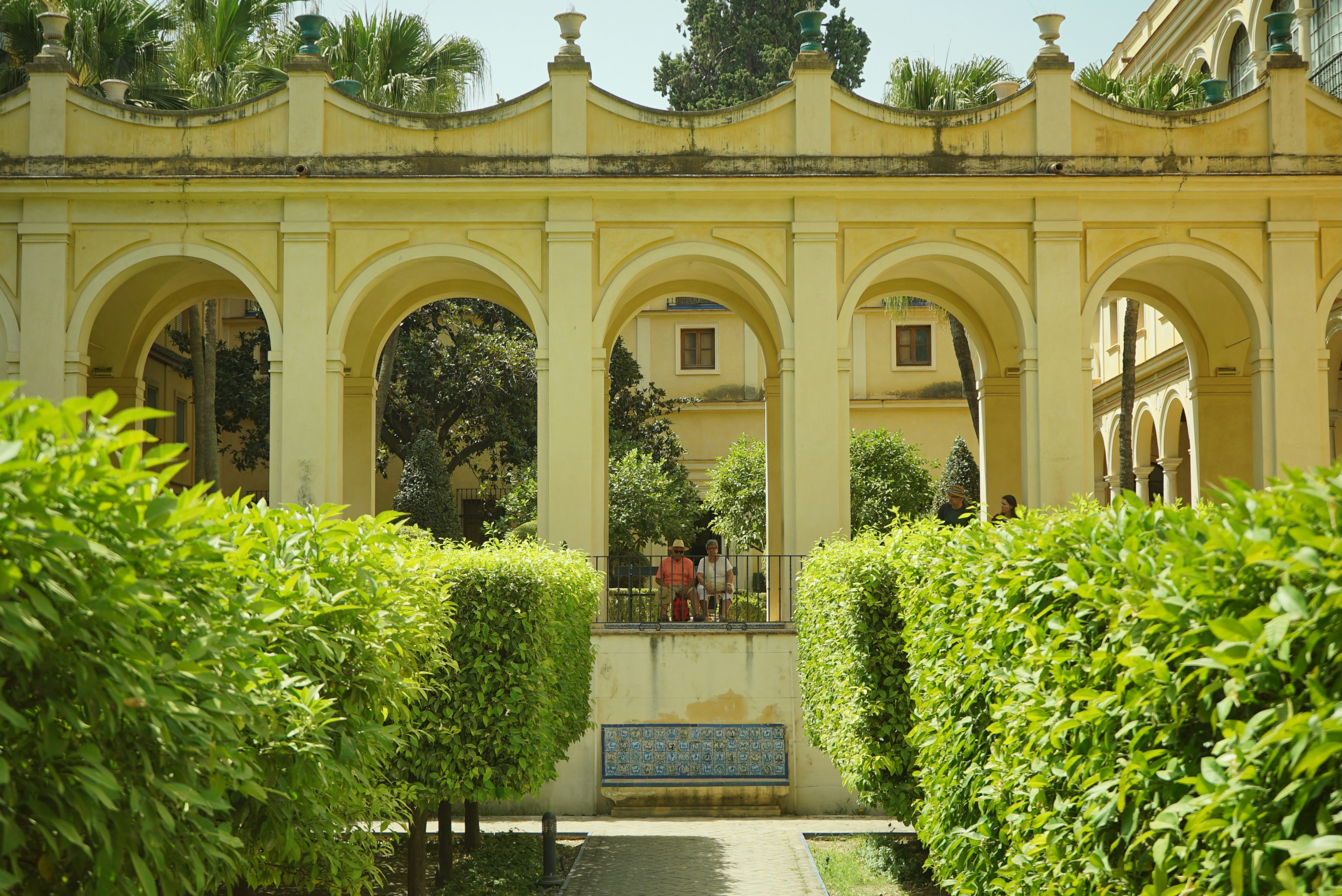 Sunlit Colonnade Garden: A Framed View Through Yellow Arches