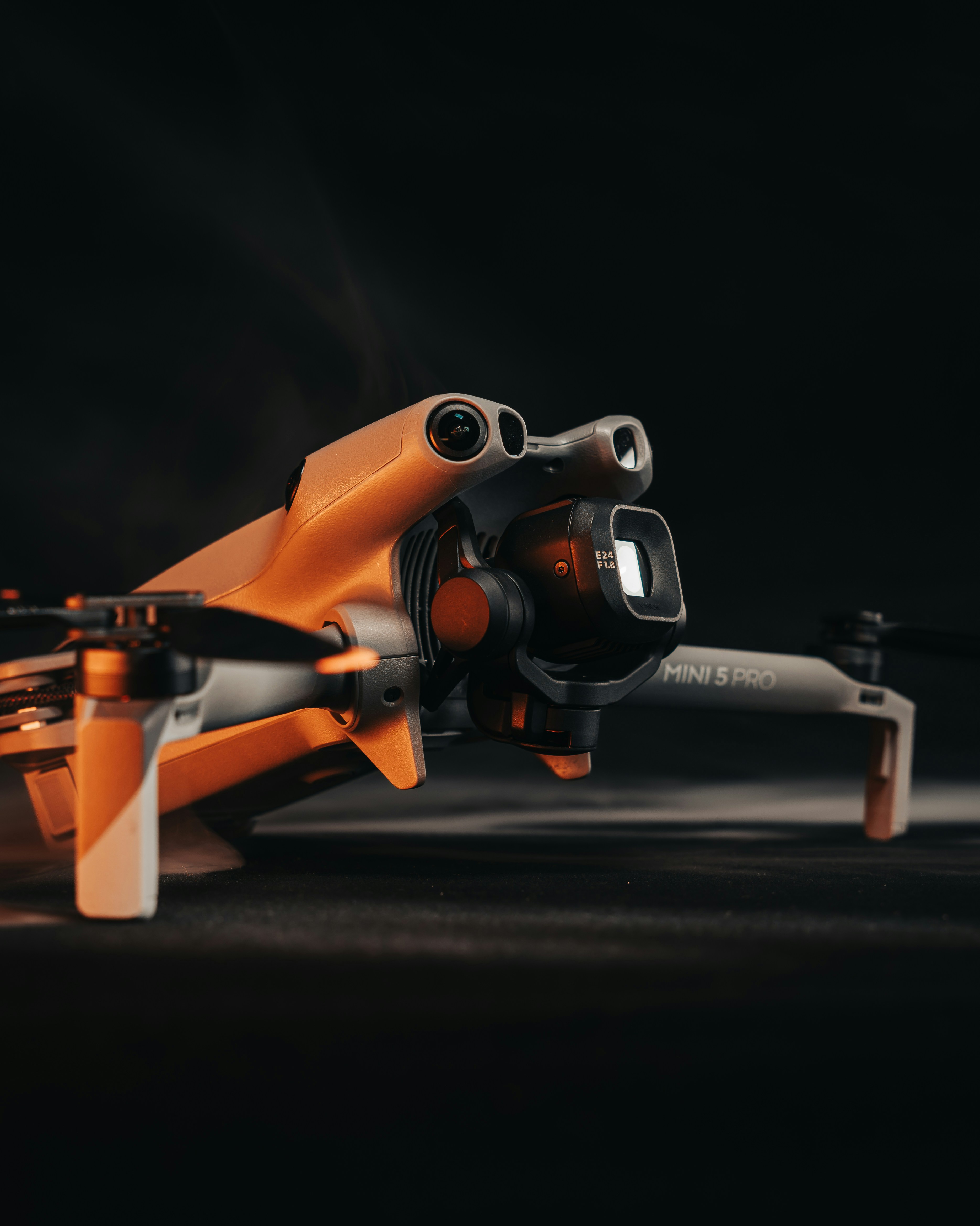 Orange drone chassis under dramatic shadow reveals precision engineering