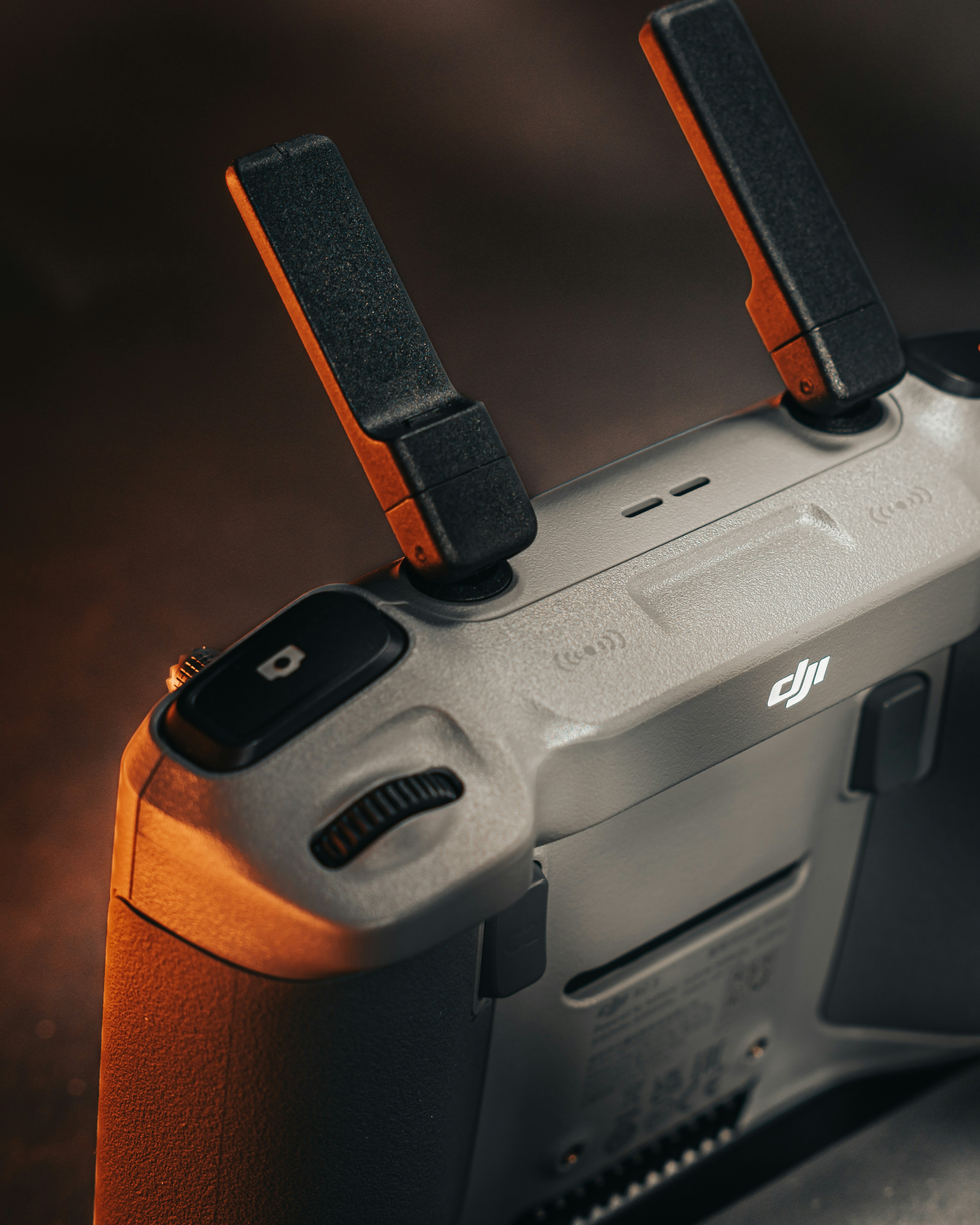 Close‑up of a DJI drone controller: chrome lettering and dual antennas