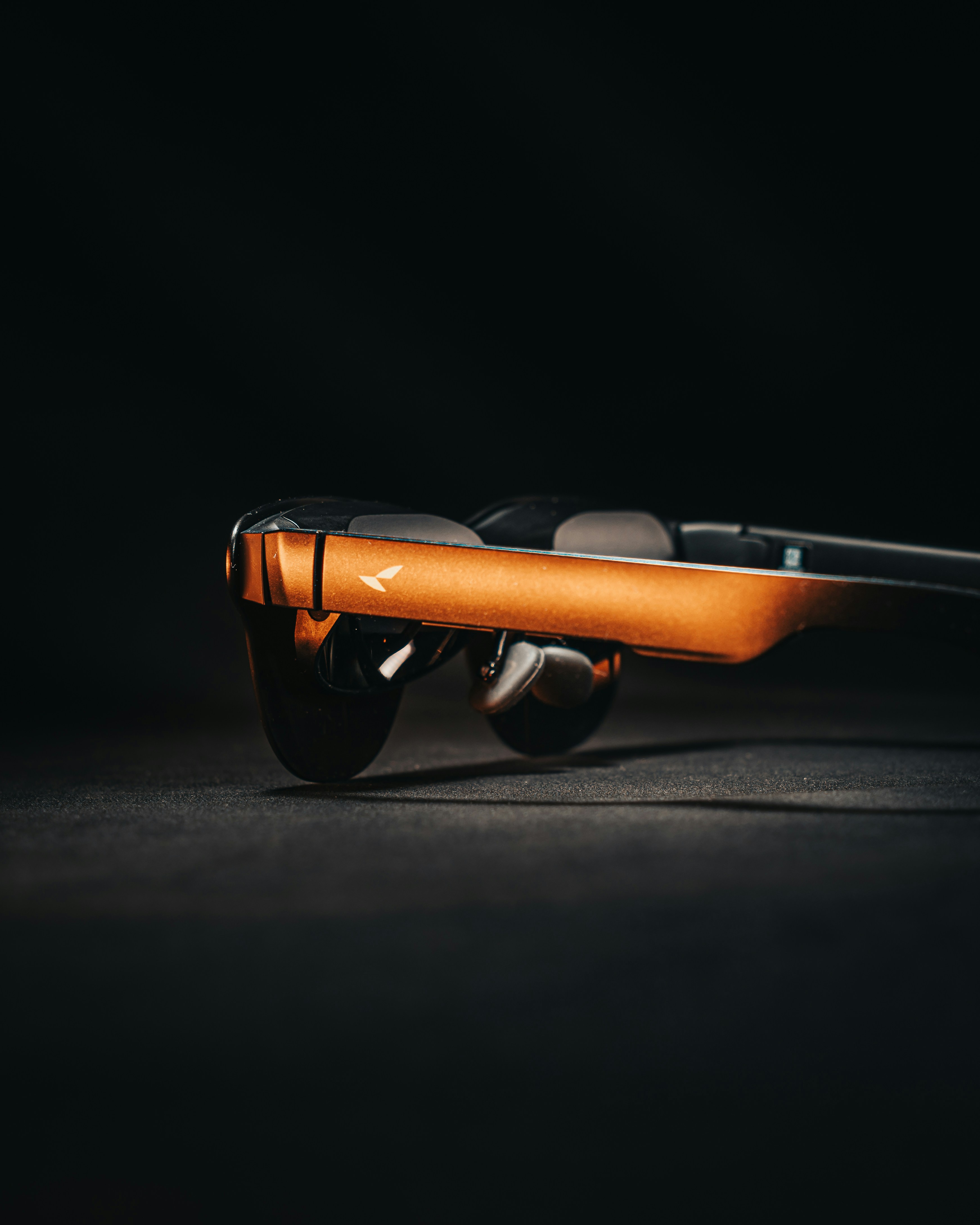 Copper Frame Sunglasses Resting on a Dark Surface