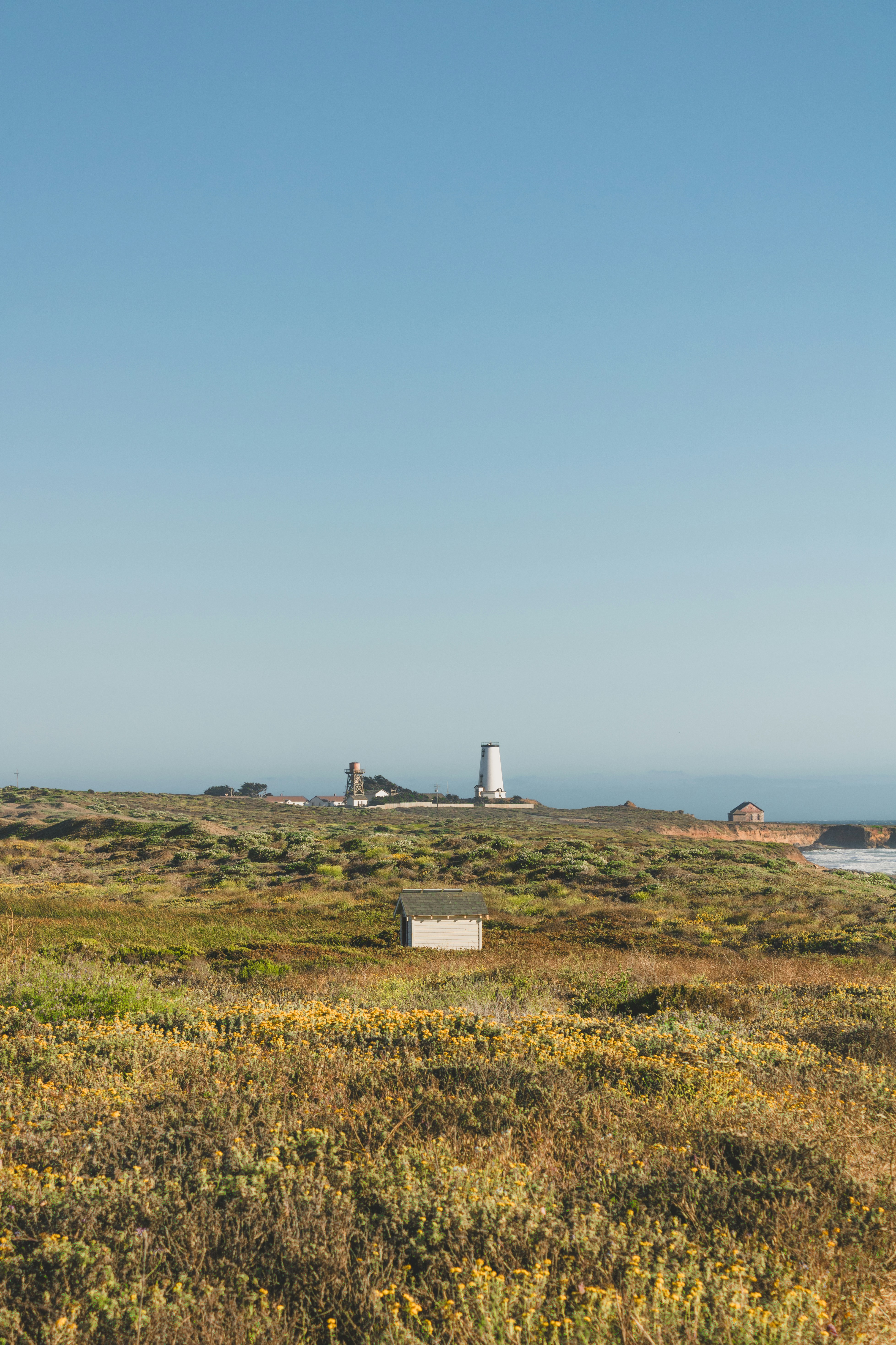 Coastal Plain with Lighthouses under a Wide Blue Sky