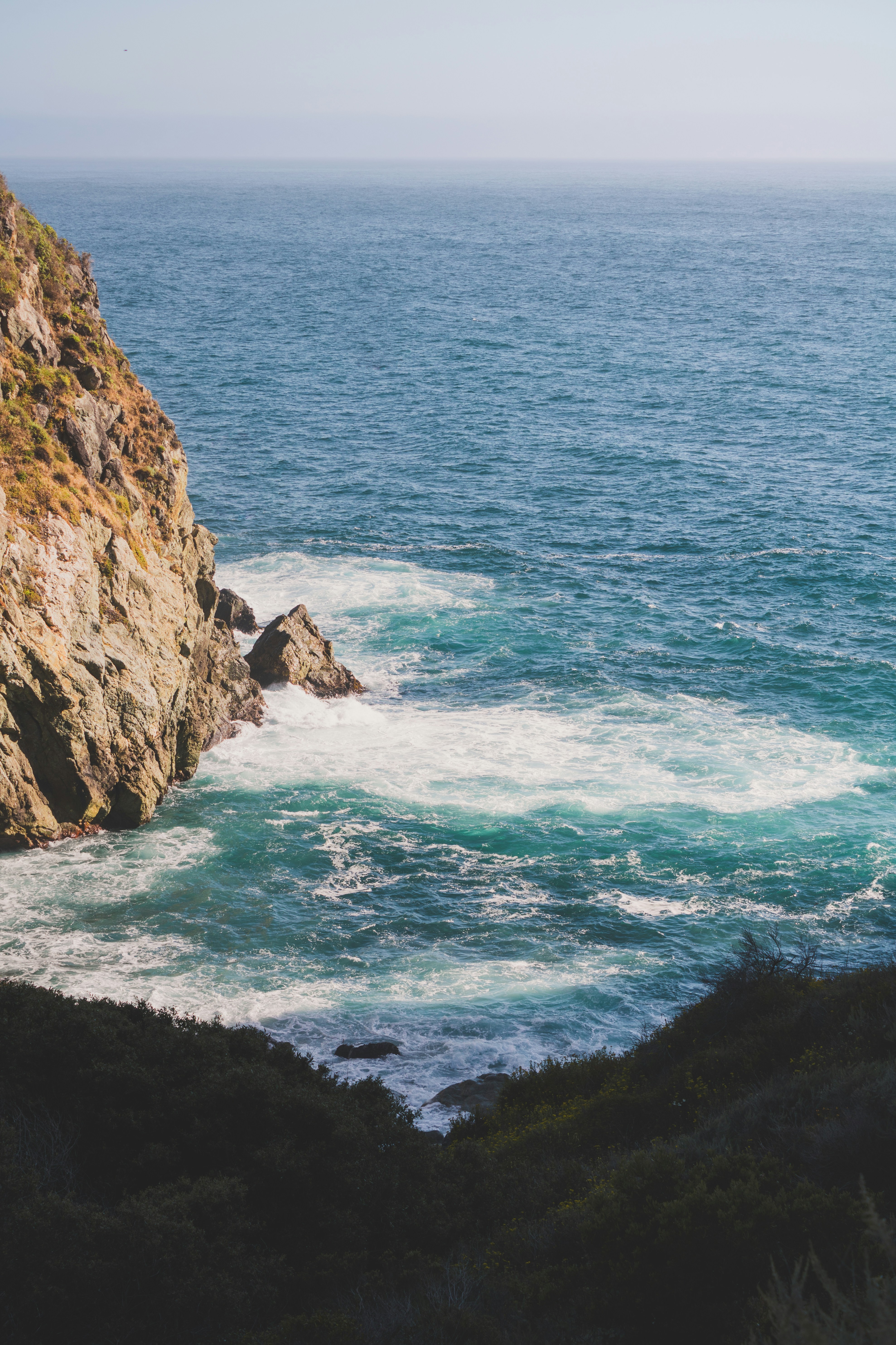Coastal Cliffside Meeting the Sea: Golden Light over Turquoise Waves
