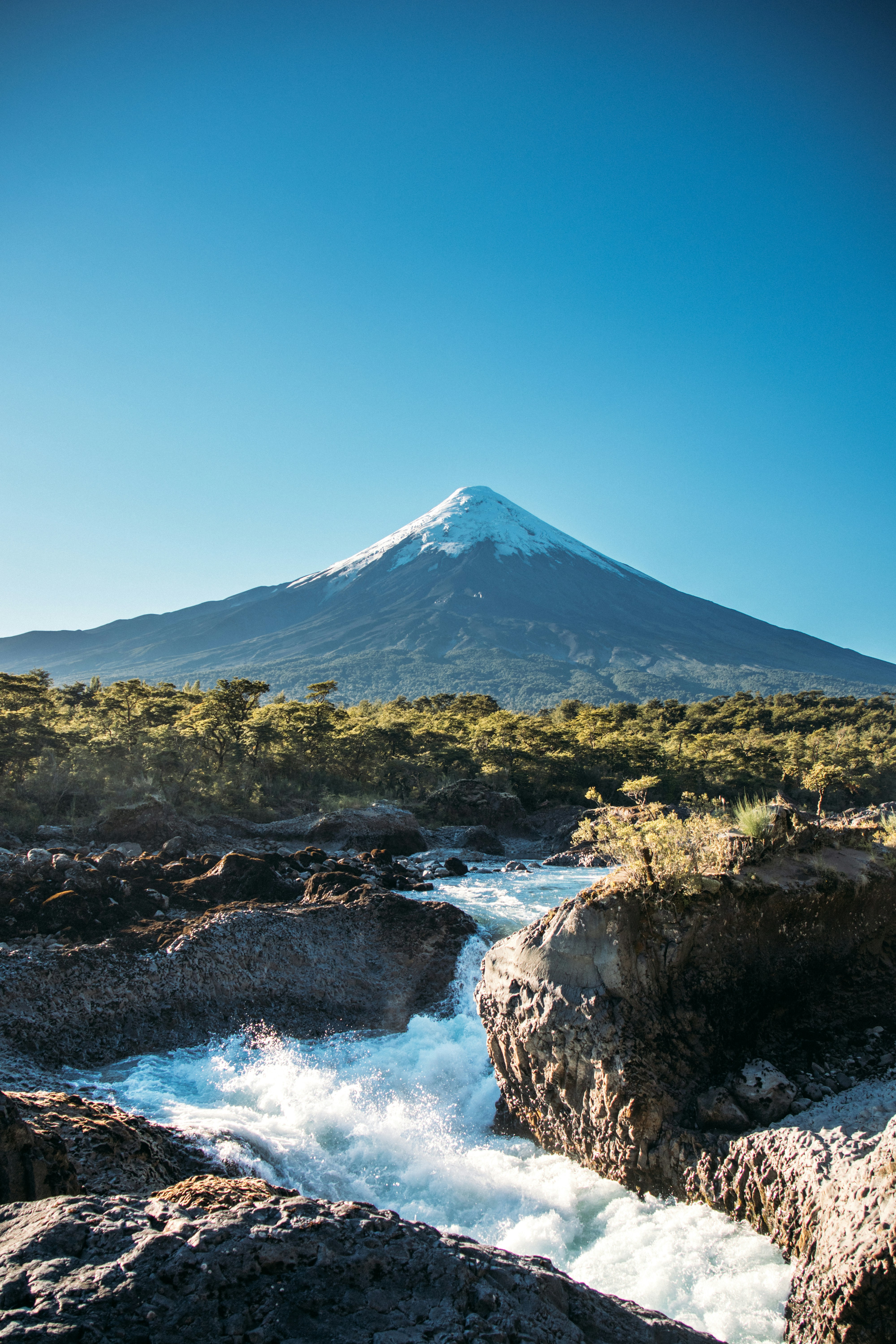 Snow-Capped Peak Over a Rugged River Gorge