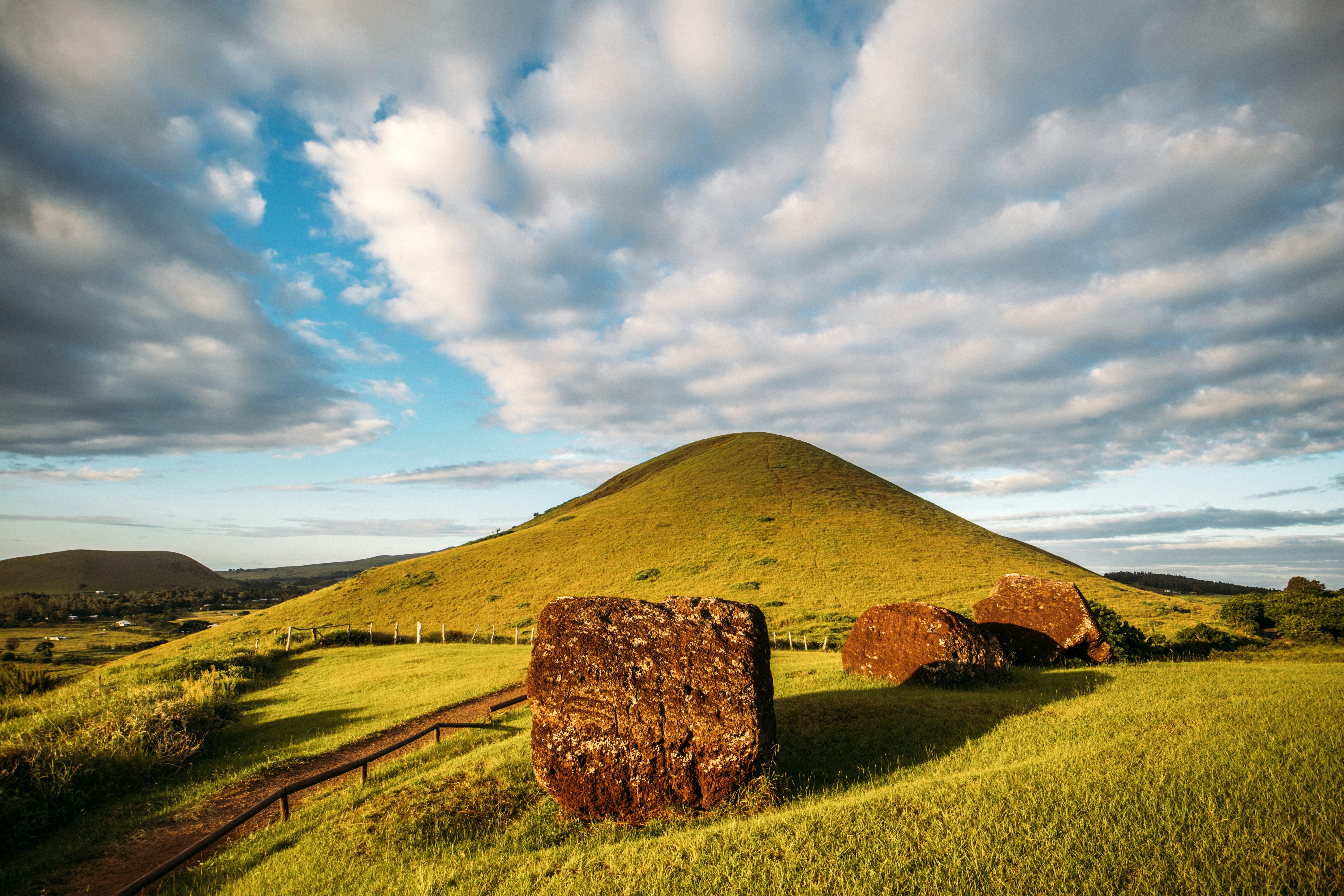Green Hill and Ancient Stones under a Spreading Sky